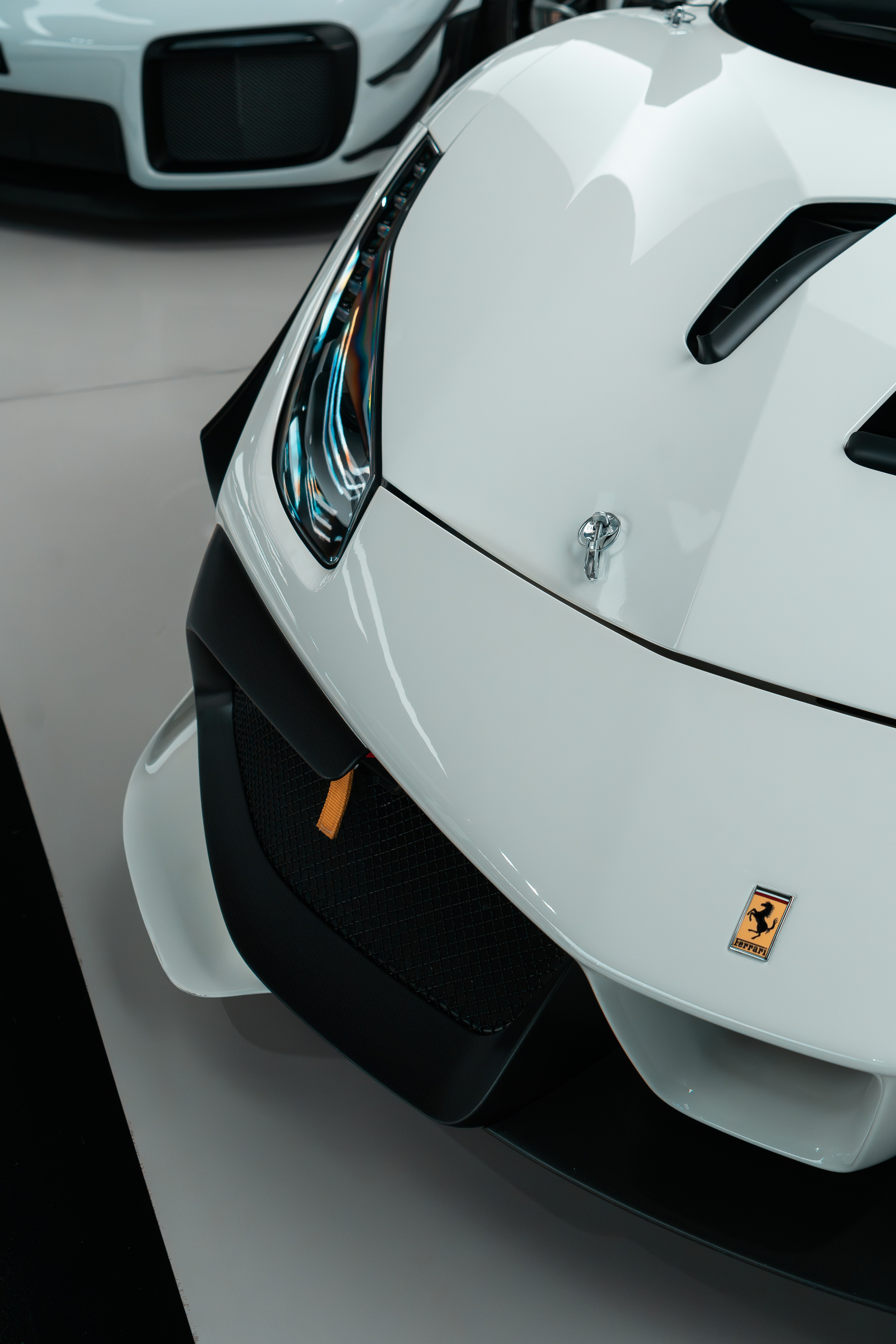 Front-End Precision: Sculpted headlight and badge on a White Ferrari