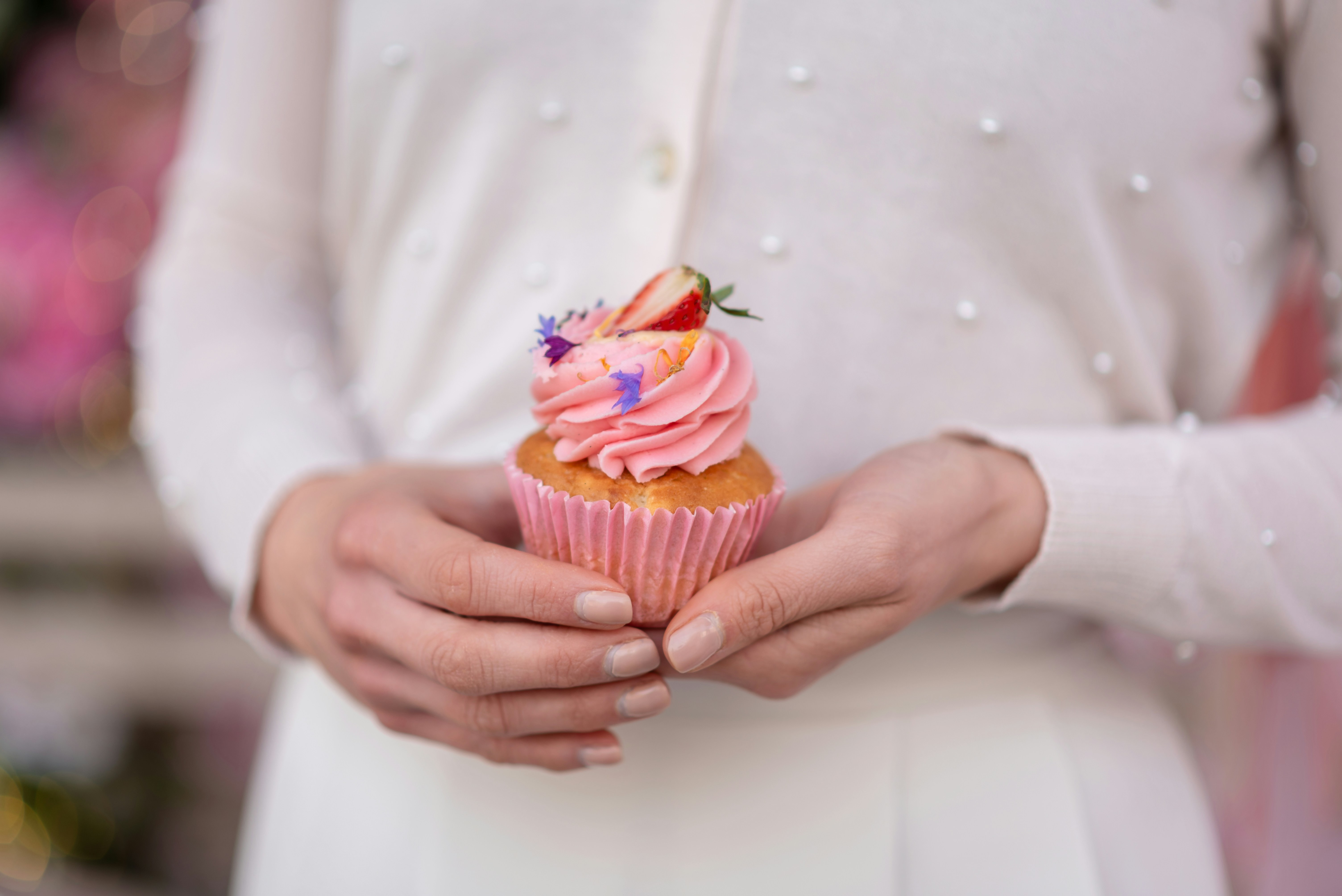 A woman holding a cupcake in her hands photo – Free Cupcake Image on ...