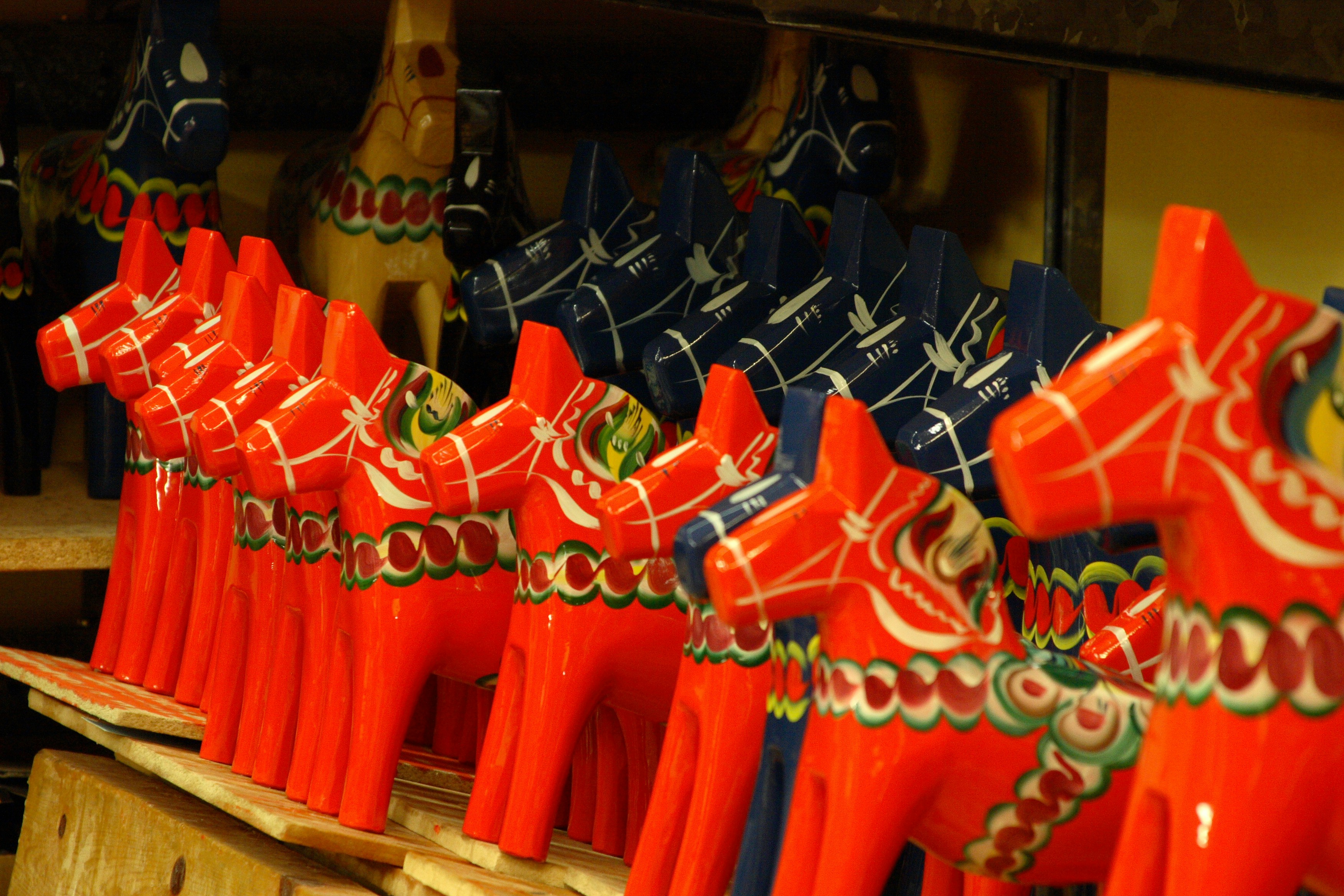 Bright Parade of Painted Horses on a Wooden Shelf