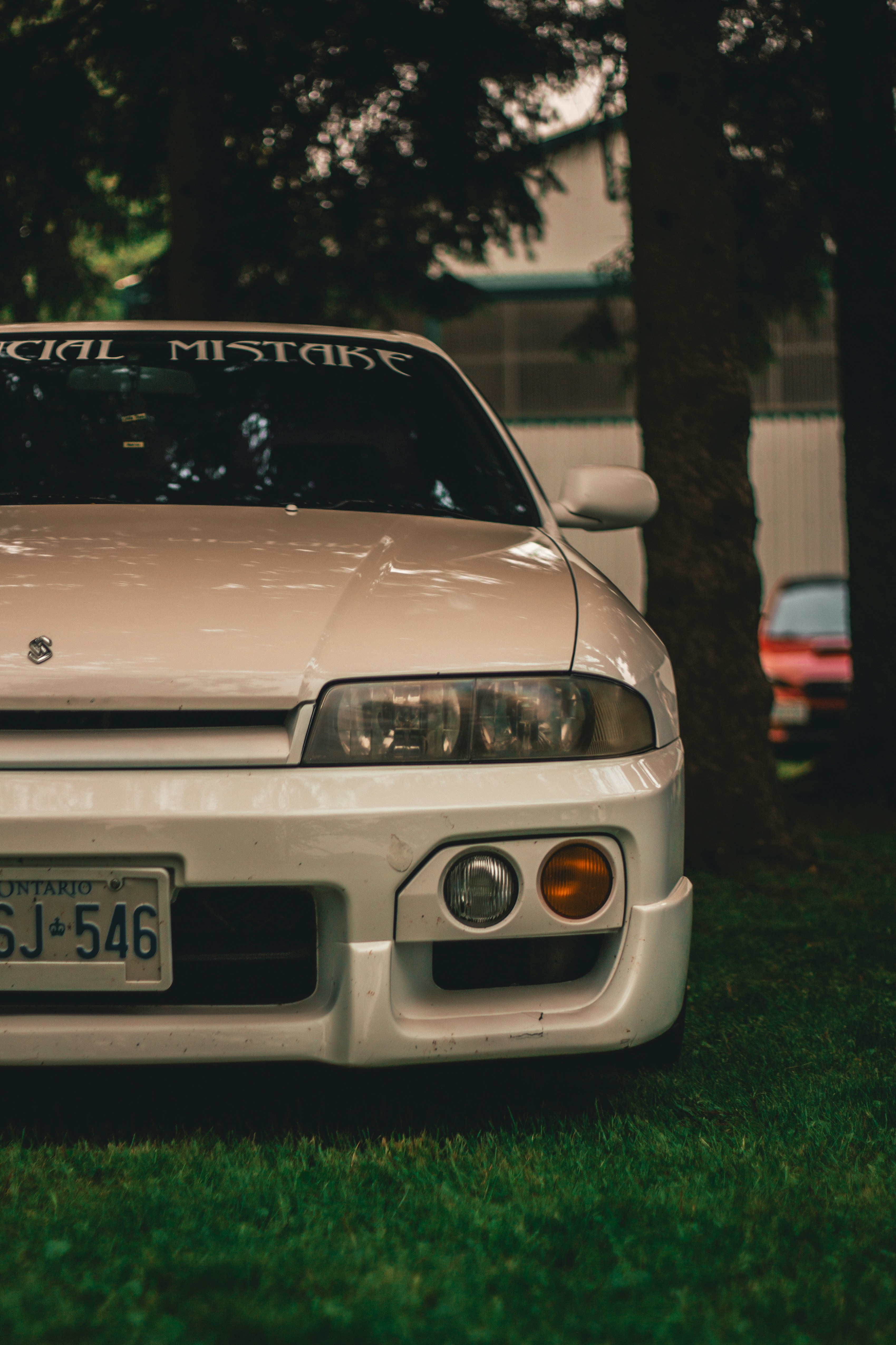 A white car parked on top of a lush green field photo – Free Nissan r33 ...