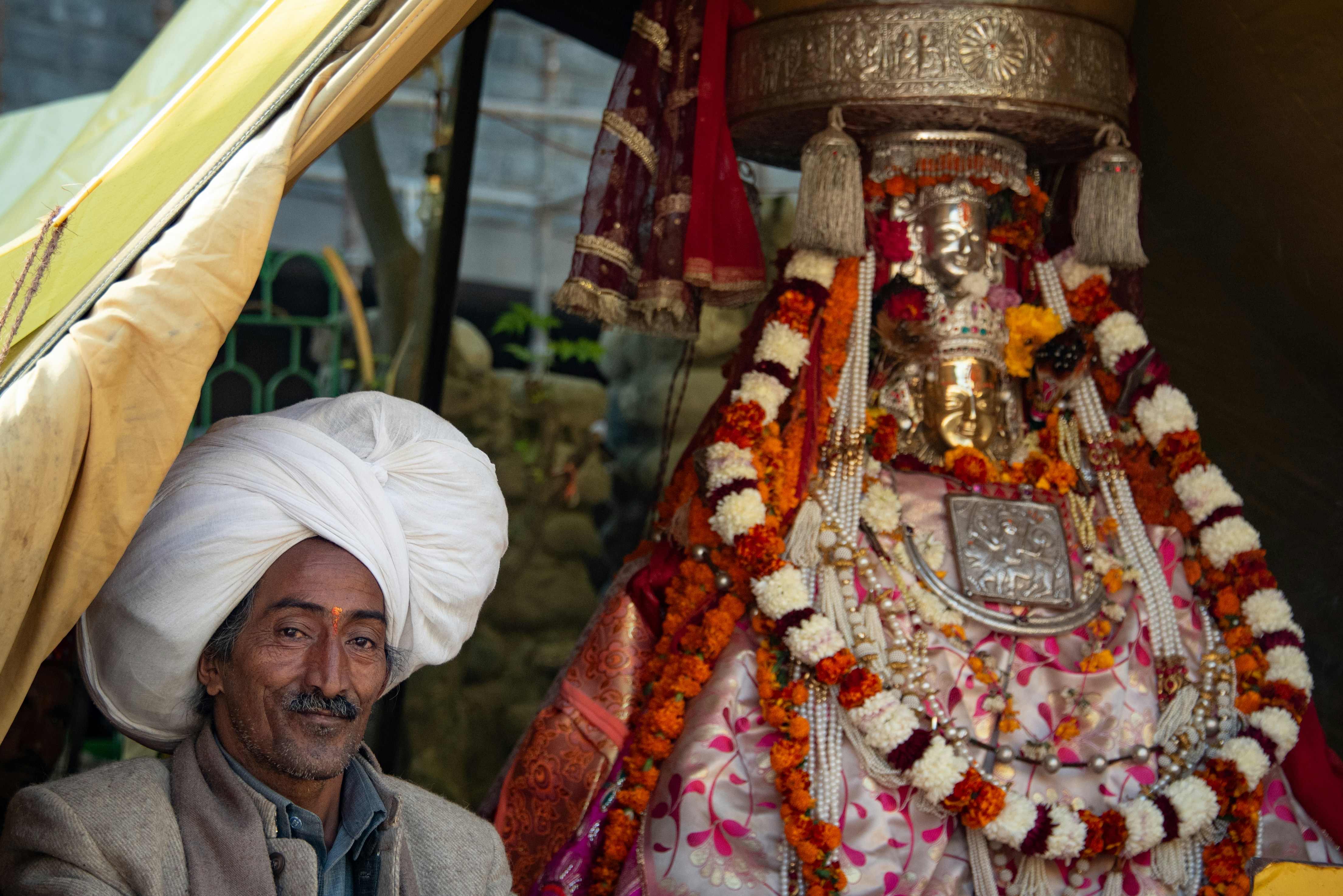A man in a turban standing next to a statue photo – Free Tradtition ...