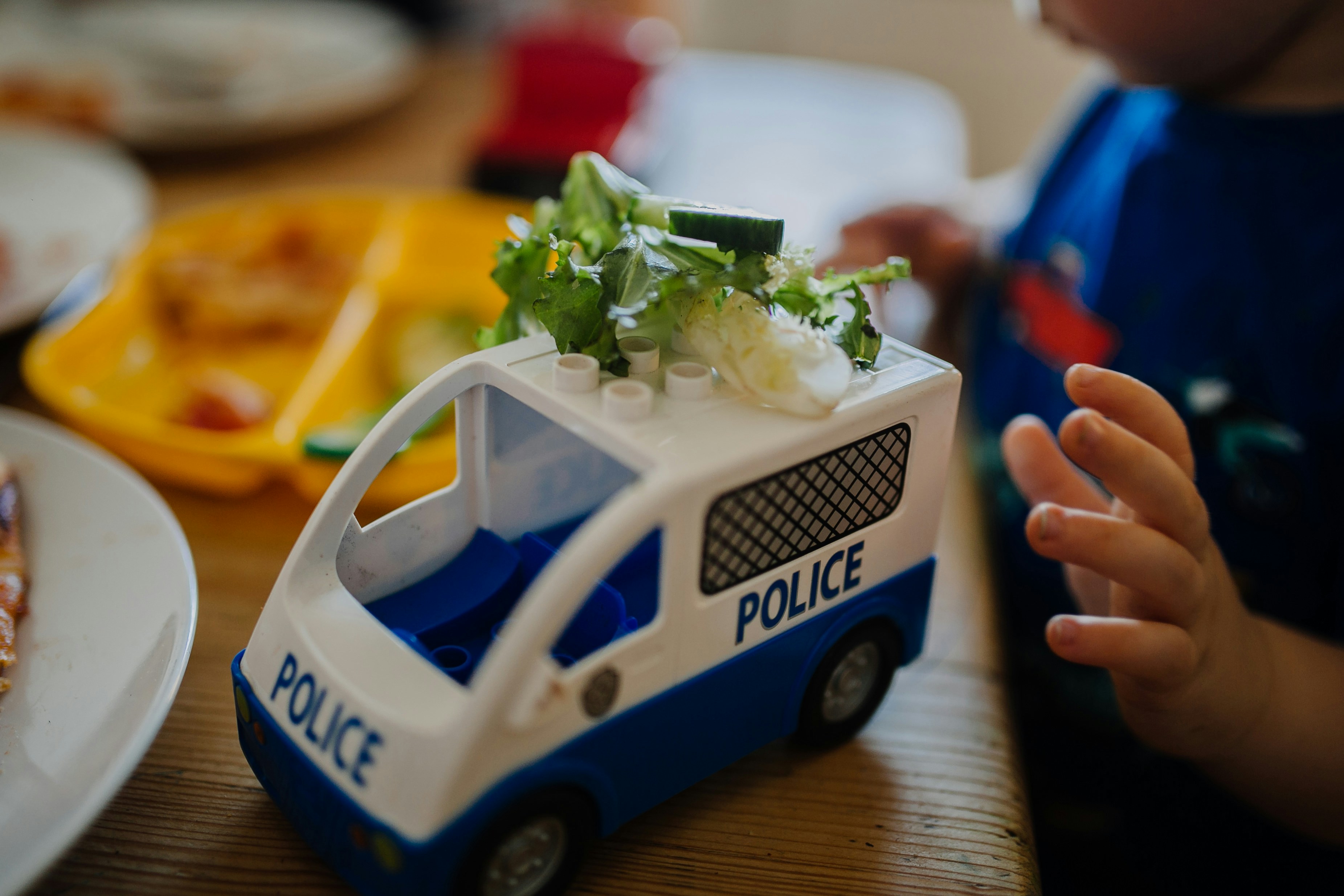 Parsley-Crowned Toy Police Cruiser in a Kids’ Snack Moment