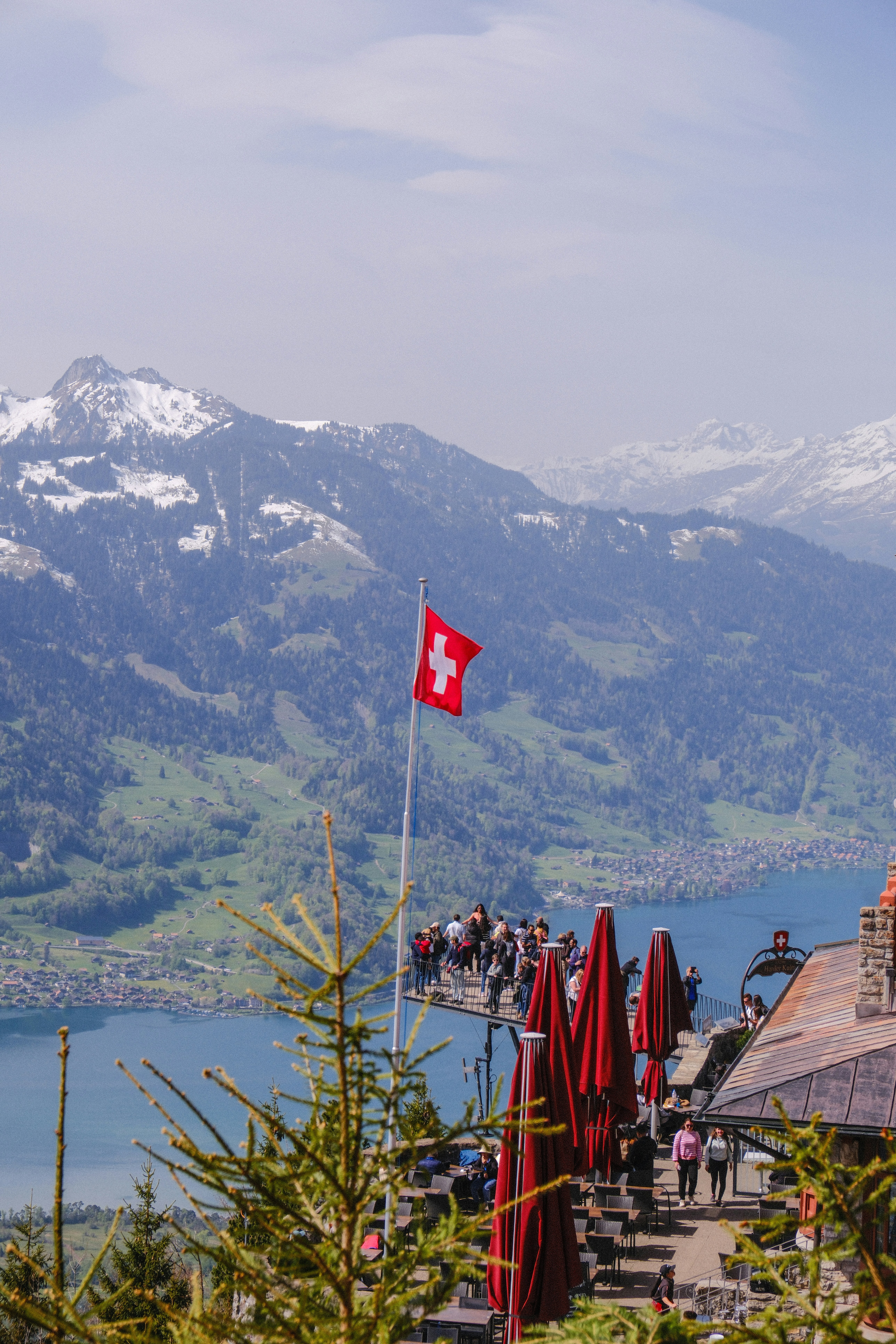 a red flag flying in the wind on top of a mountain