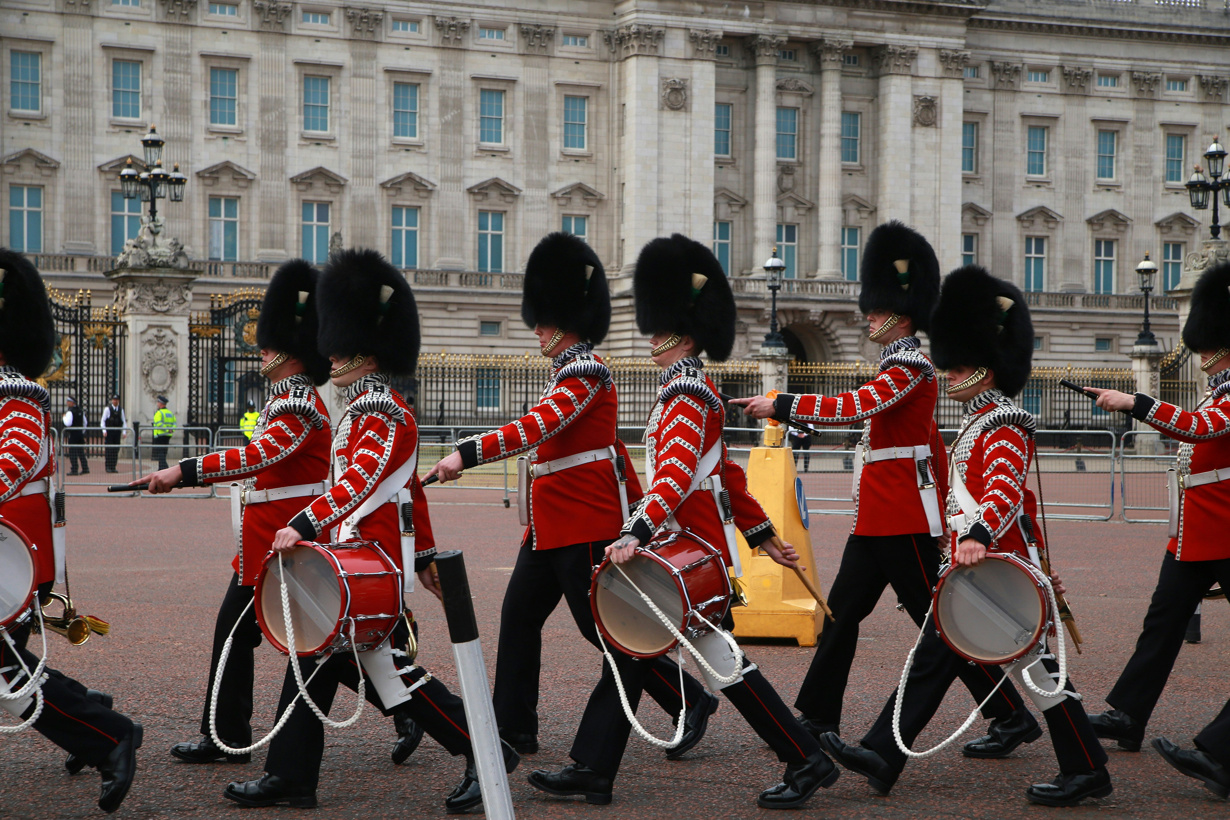 A group of men in uniform marching down a street photo – Free Reino ...