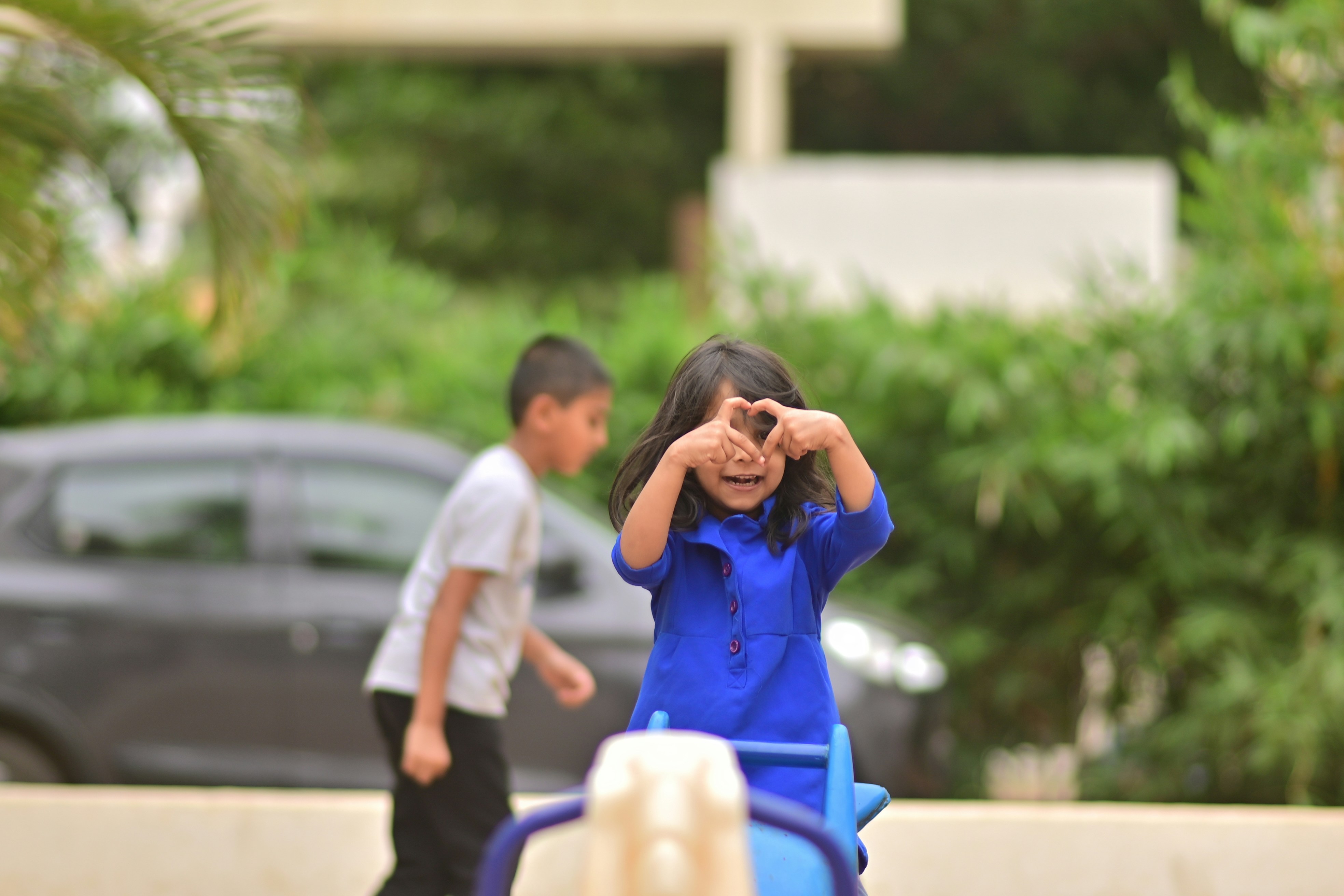 Framemaker in Blue: A candid moment of play in a sunlit courtyard