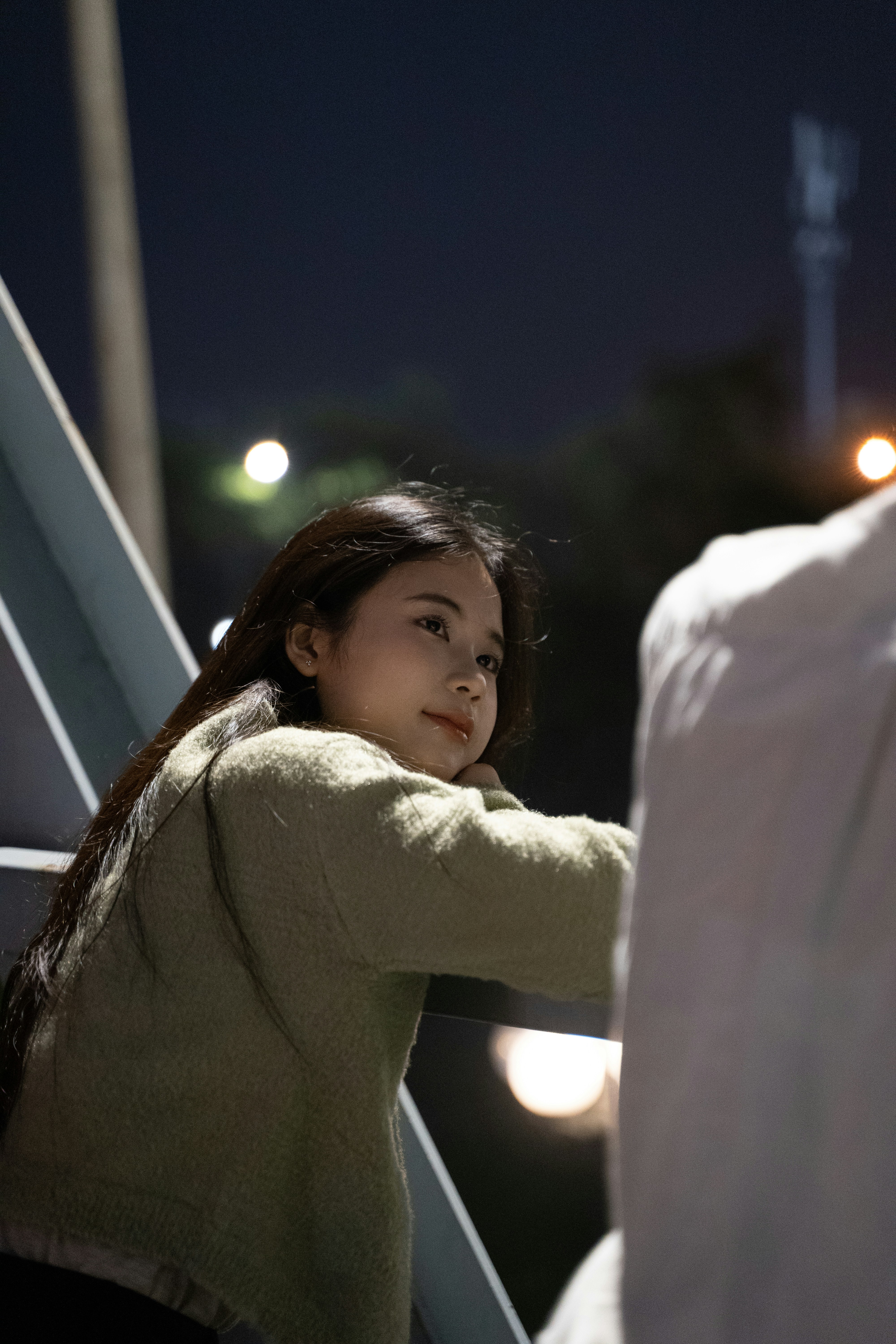 A woman leaning on a rail at night photo – Free Couple Image on Unsplash