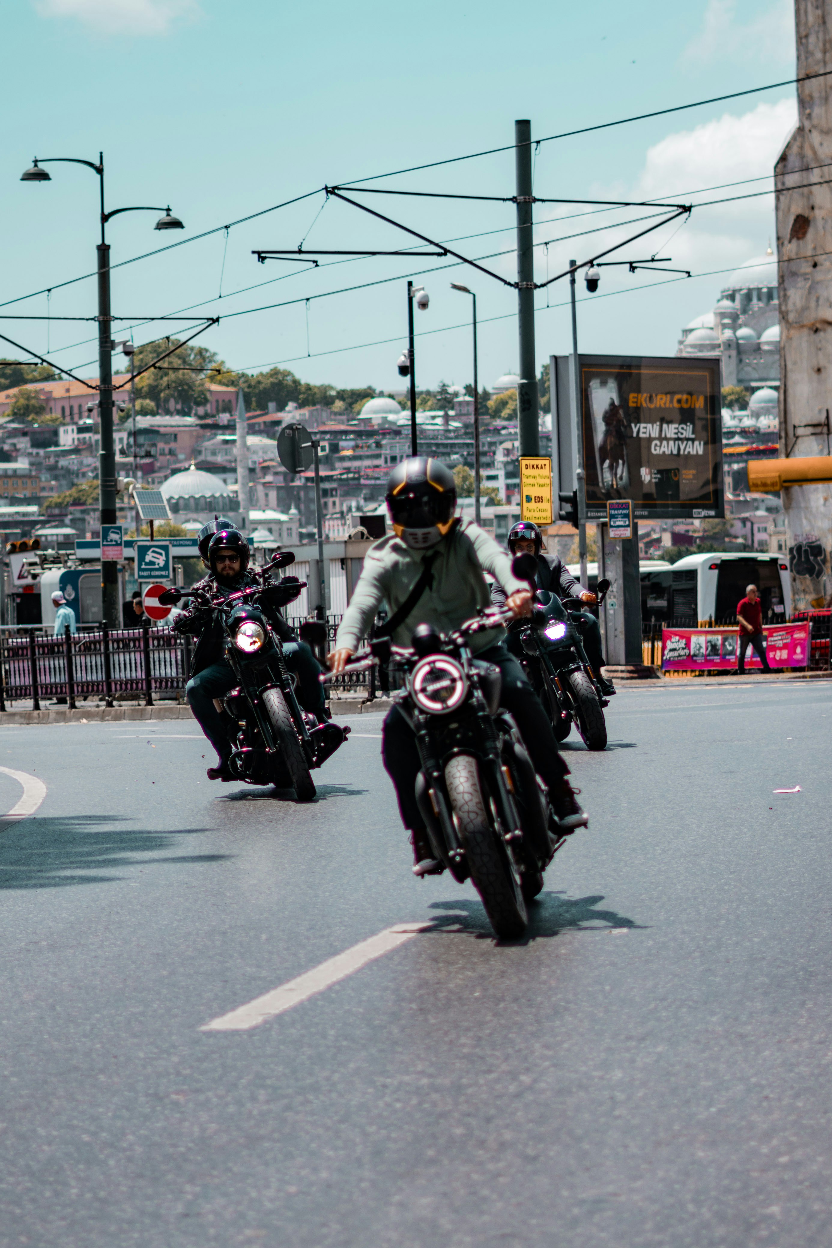 A group of people riding motorcycles down a street photo – Free ...
