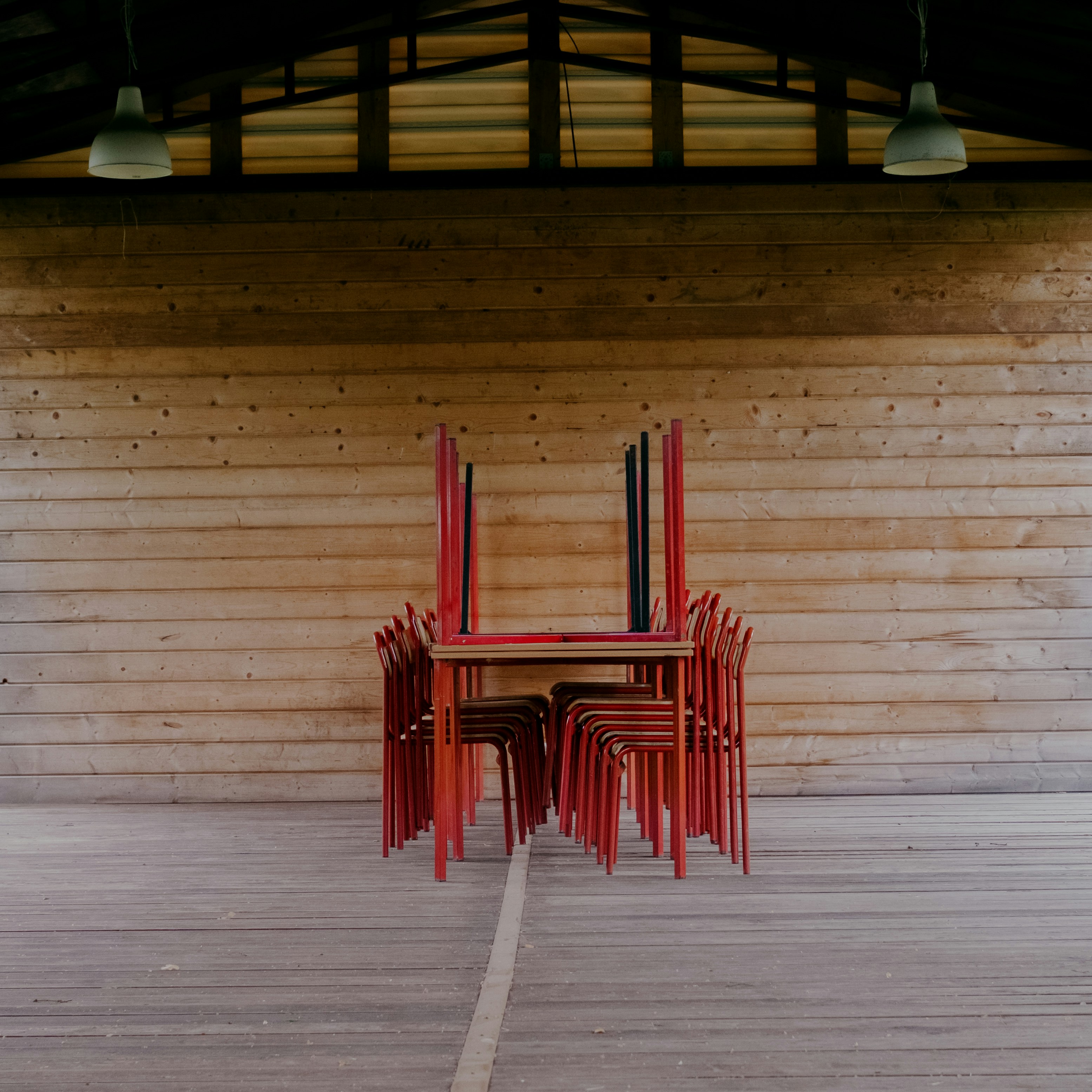 Crimson Chair Stack: Symmetry in a Quiet Wooden Hall