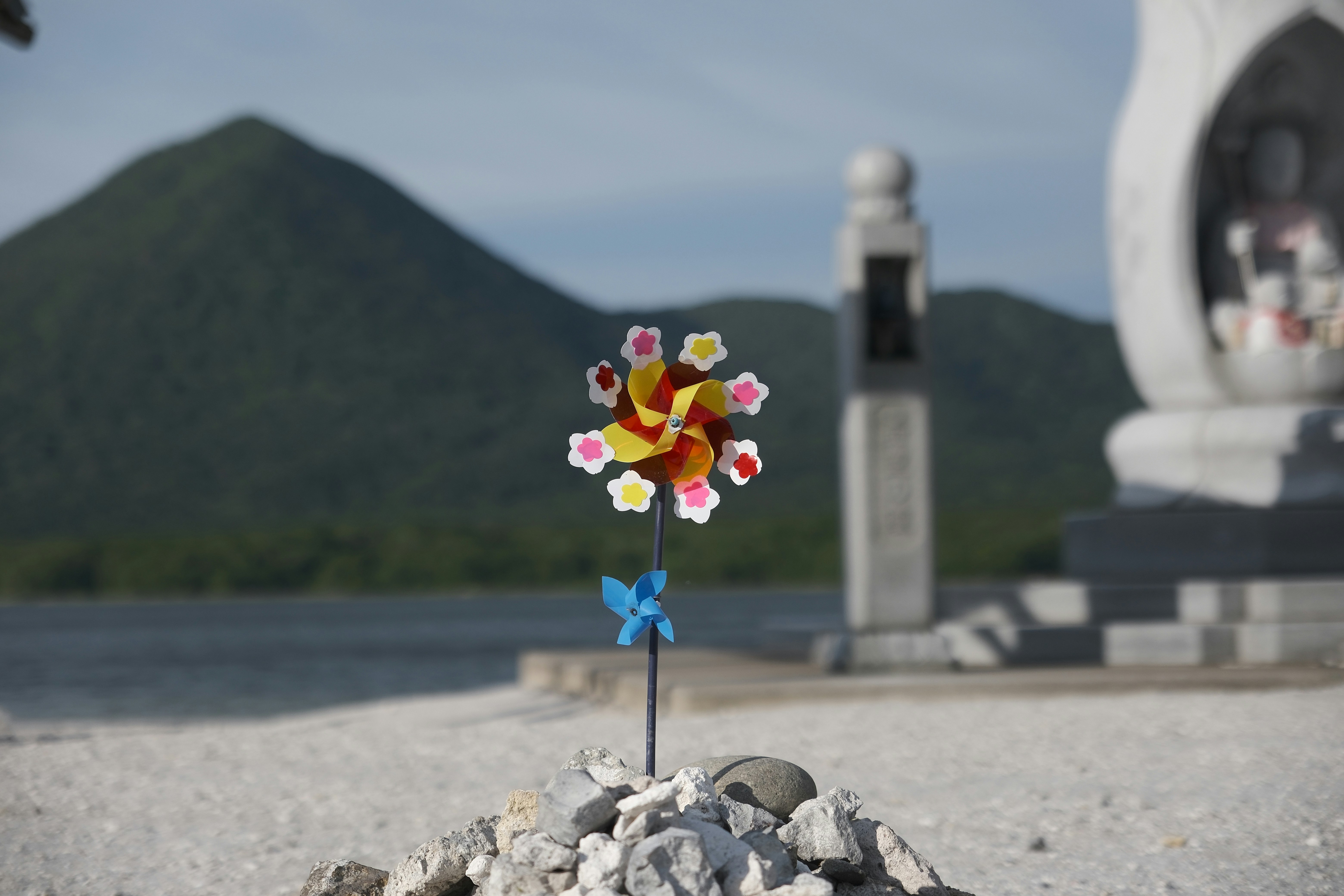 A colorful pinwheel on a rock near a body of water photo – Free Aomori ...