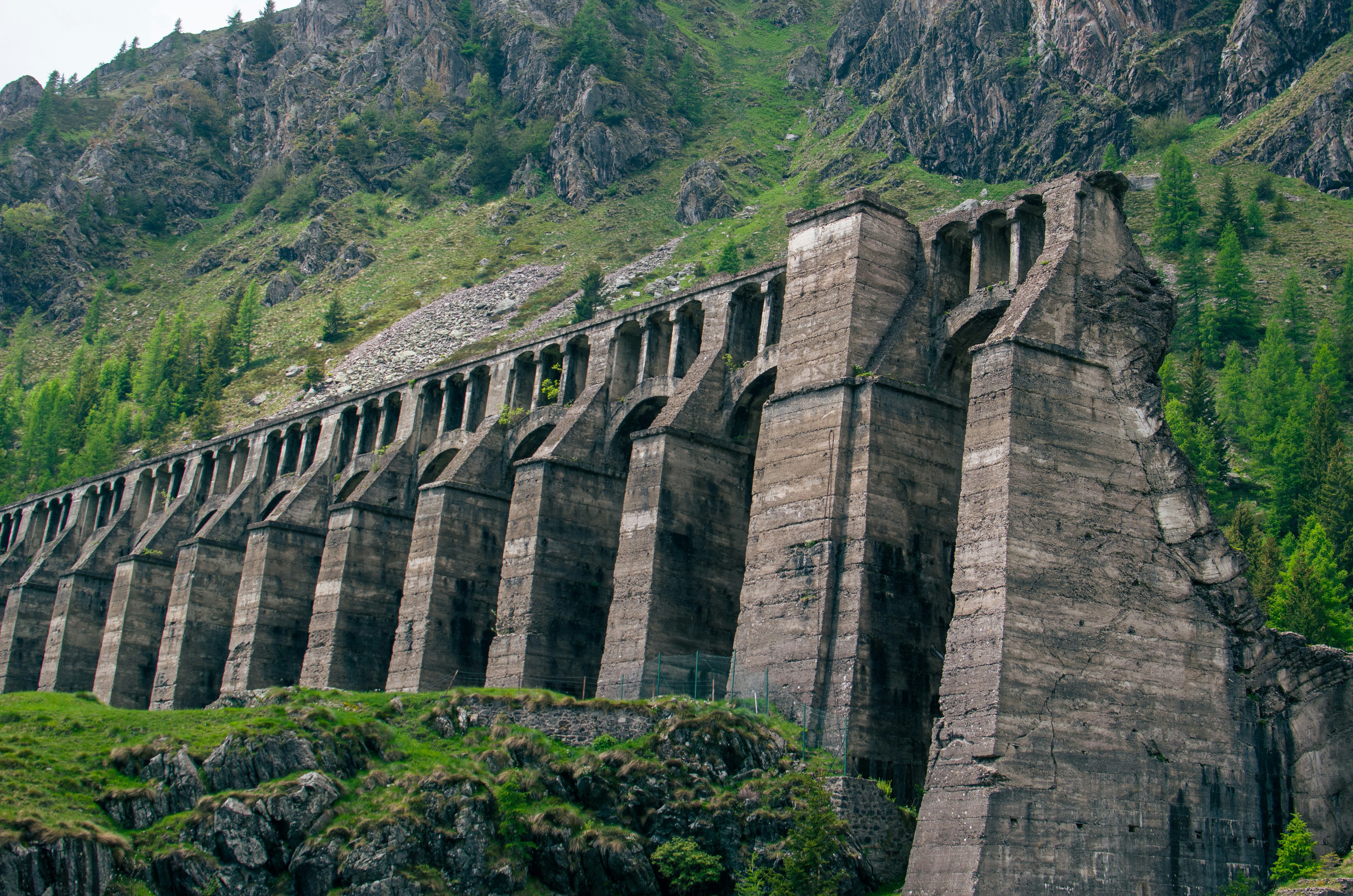 A large stone bridge surrounded by a lush green hillside photo – Free ...