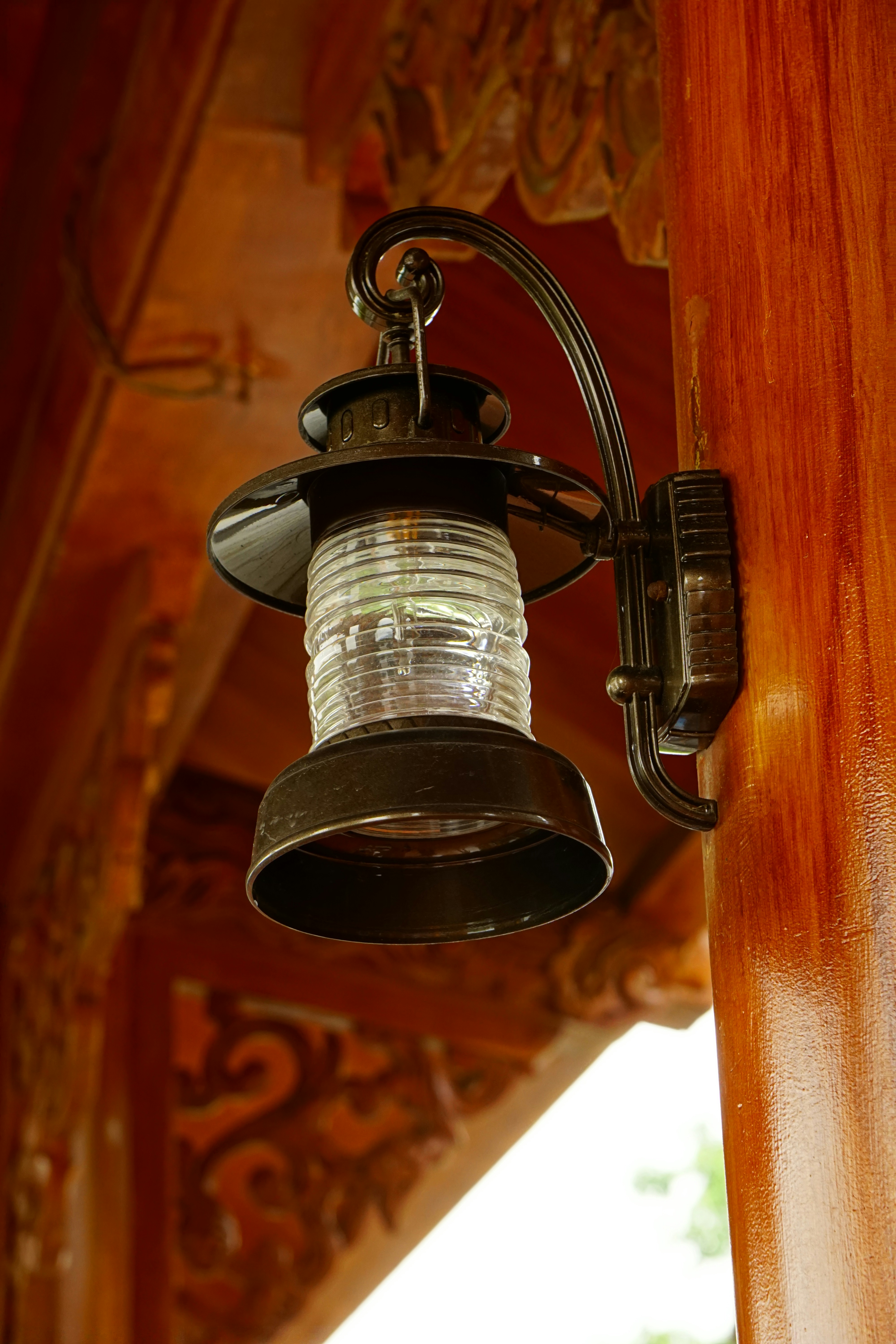 Iron Lantern Casting Warm Glow Under Carved Timber Eaves