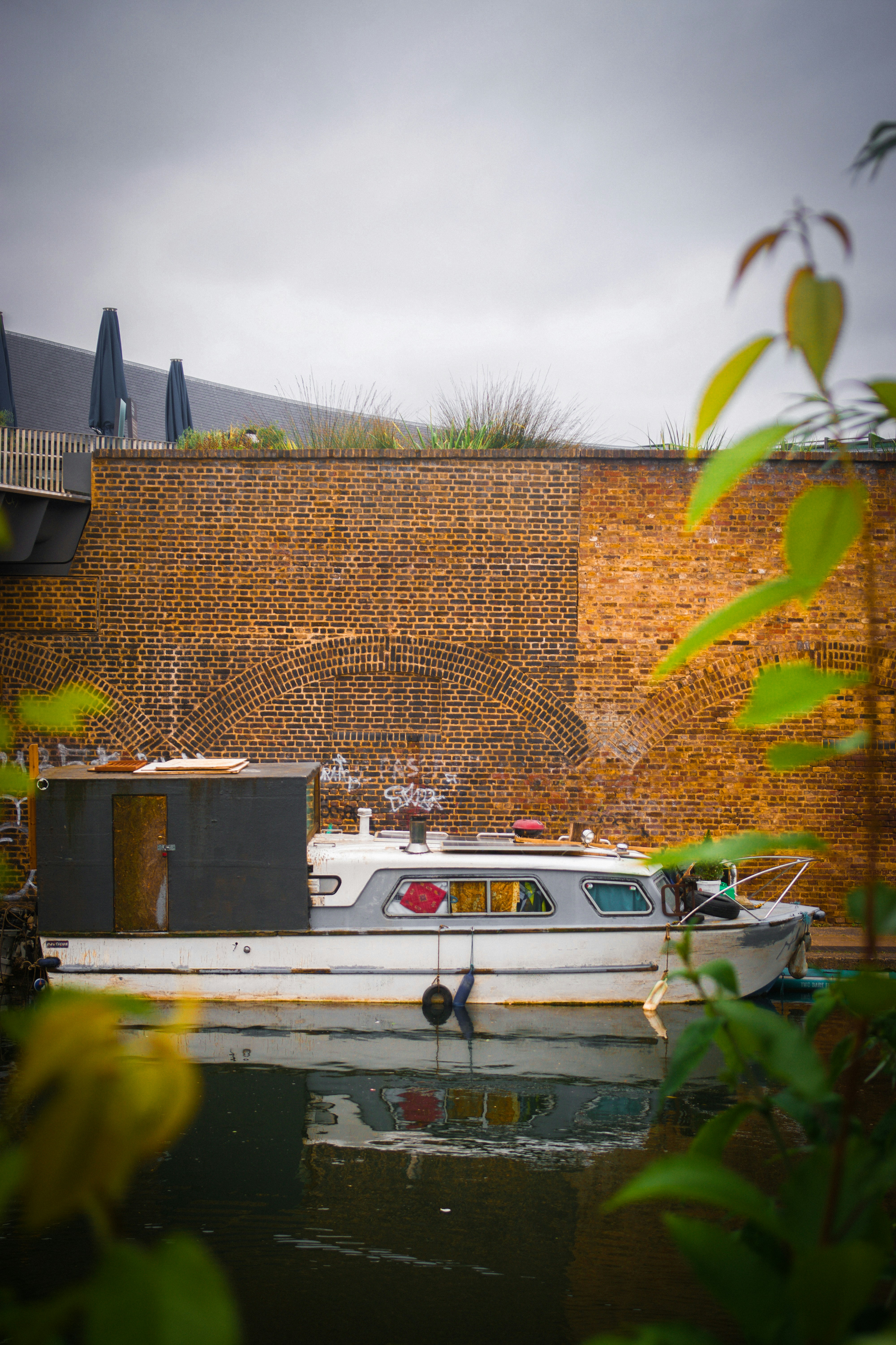 Arches on the Brick Wall: A Houseboat Idle by the Canal