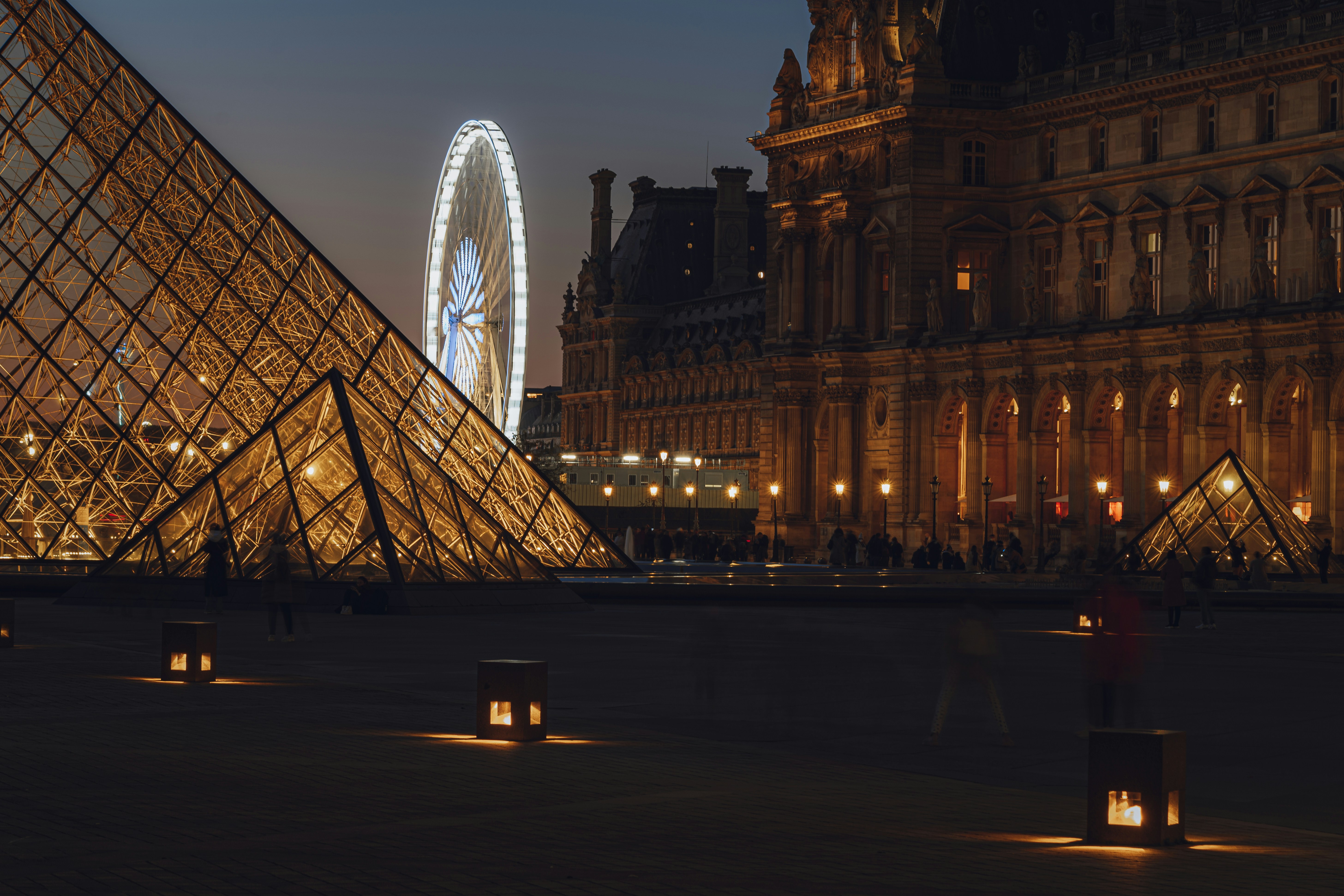 Louvre Nightscape: Glass Pyramids, Warm Lanterns, and a Distant Ferris Wheel