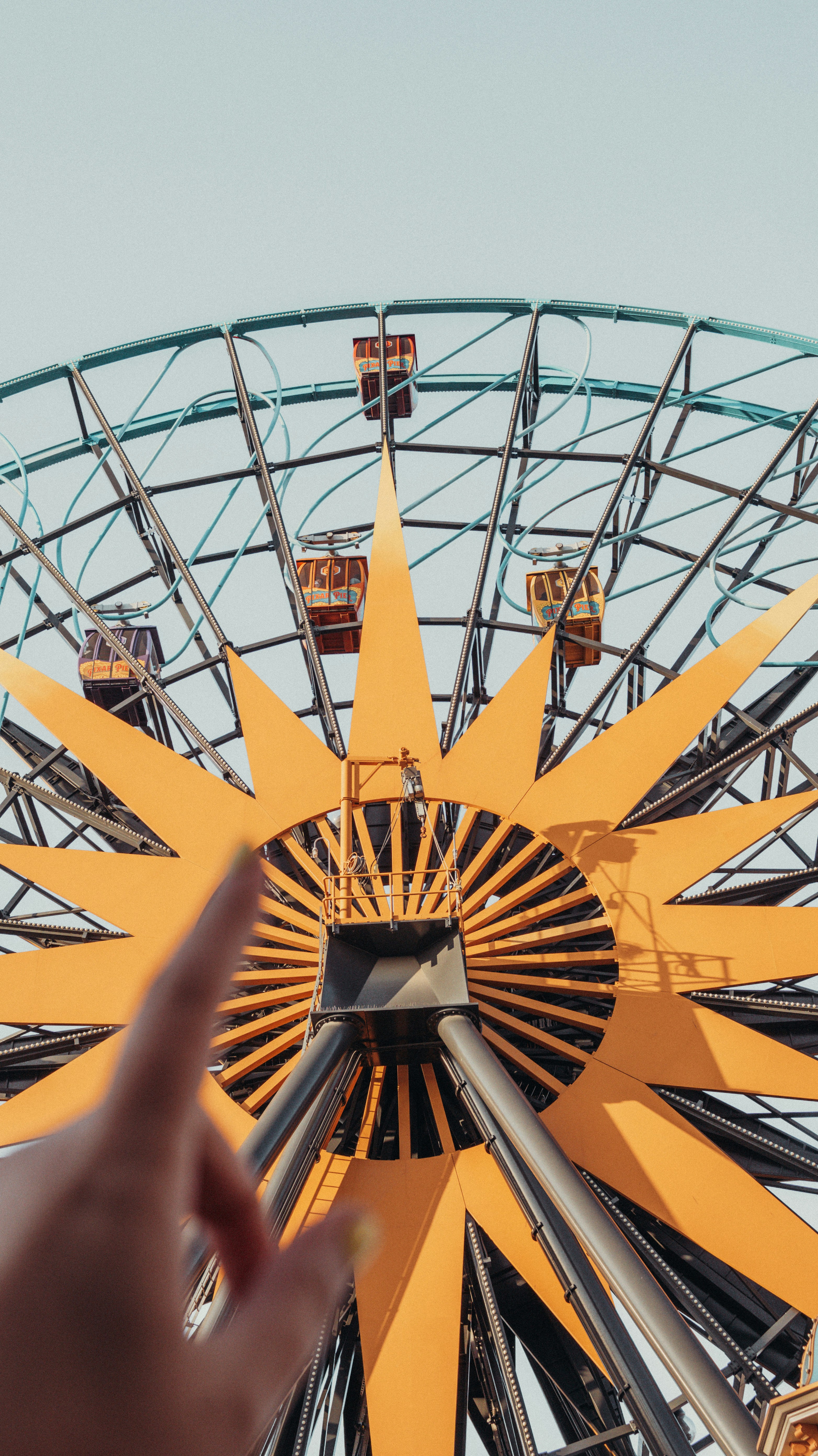 Sunburst in Steel: Ground-Level Portrait of an Orange Ferris Wheel