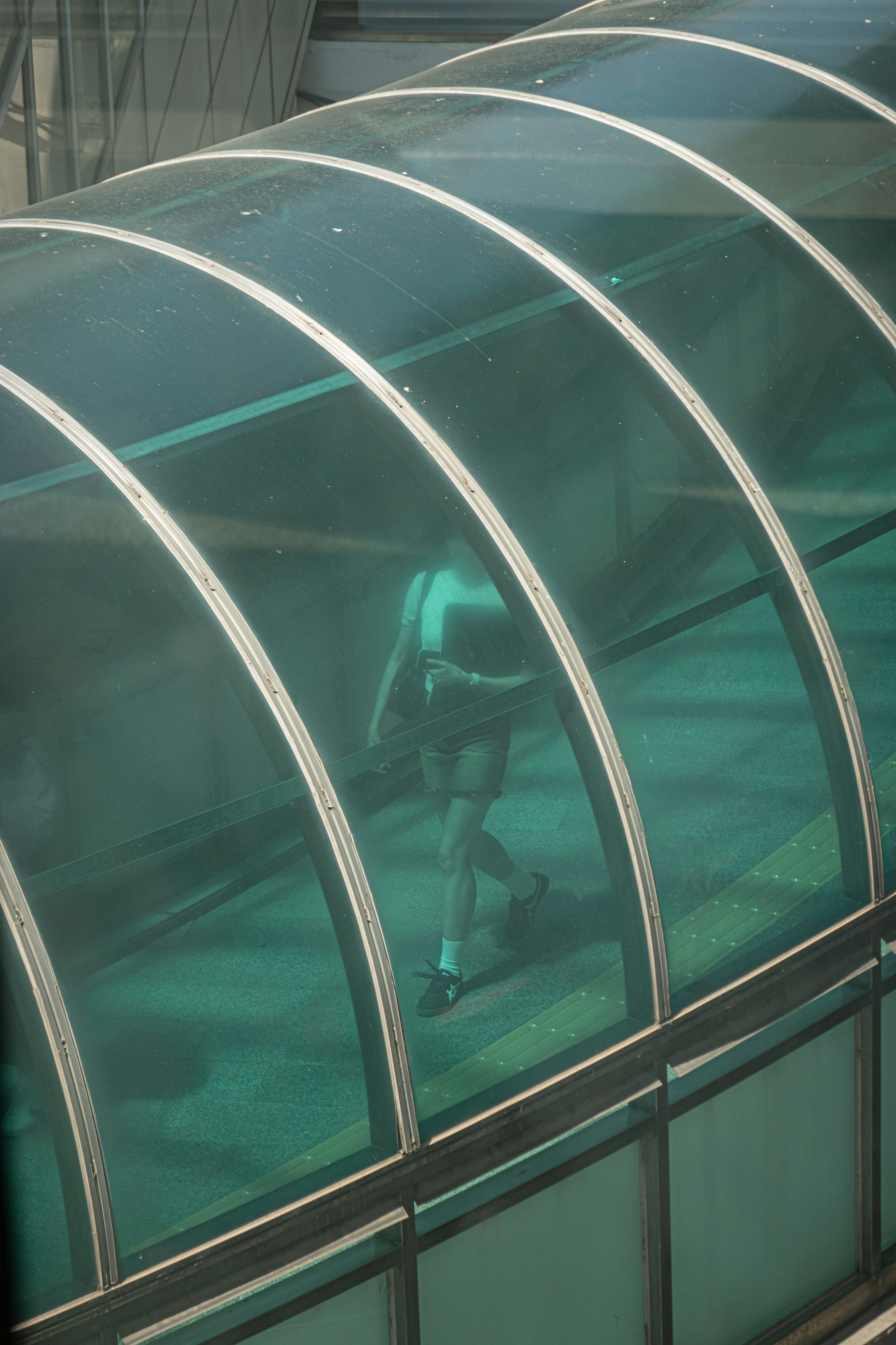 a man is reflected in the glass of a building