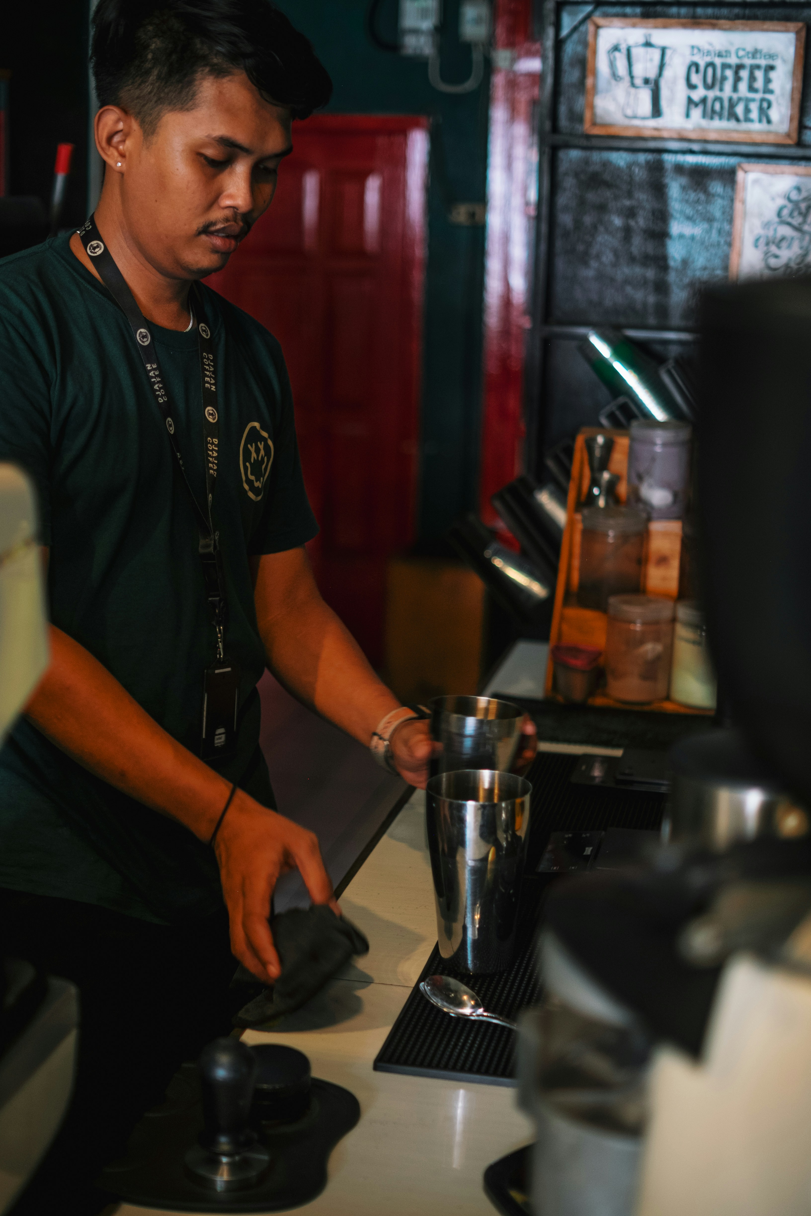 A man standing at a counter making a drink photo – Free Man Image on ...