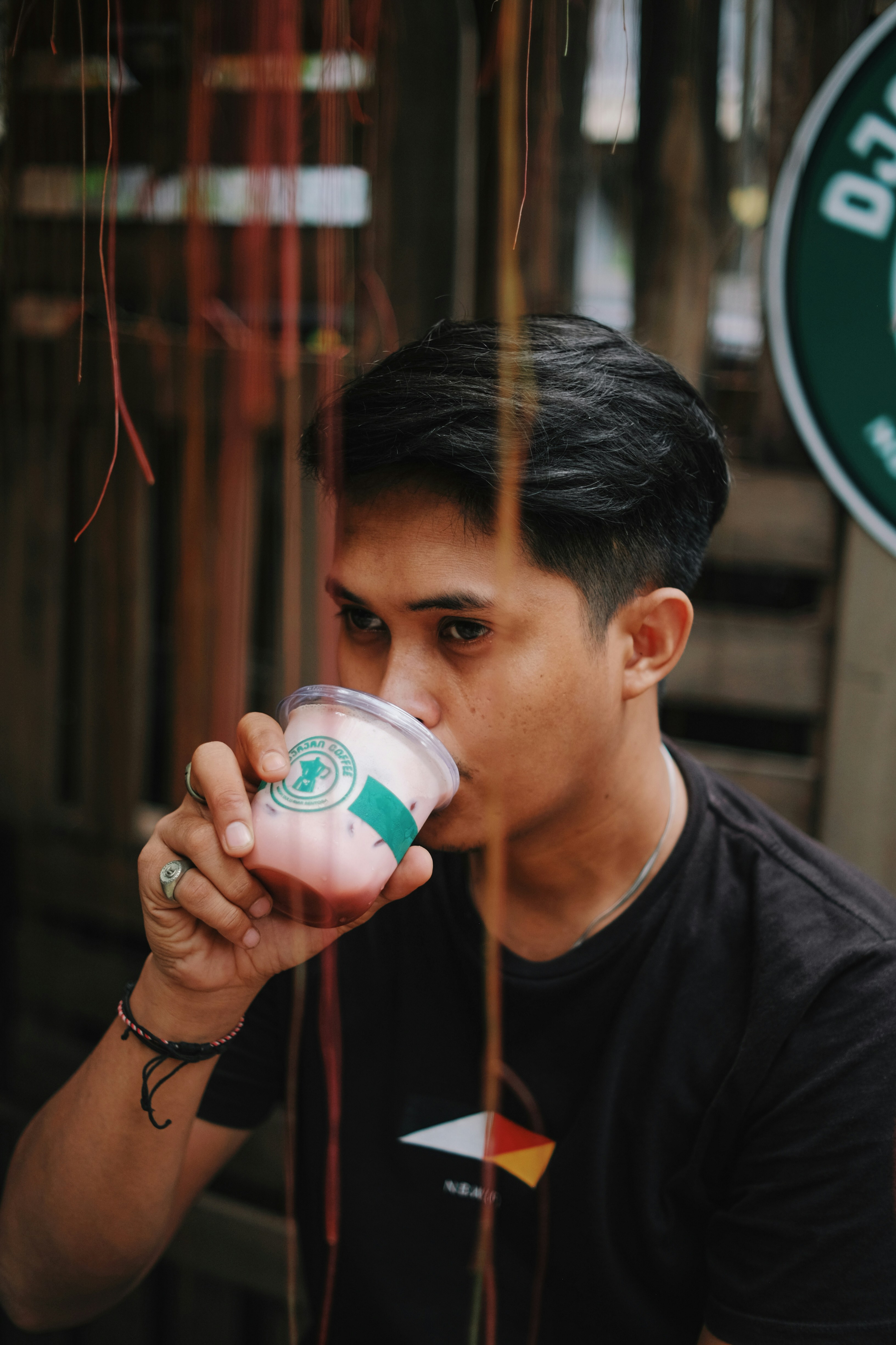 A man drinking from a cup in front of a starbucks sign photo – Free Cup ...