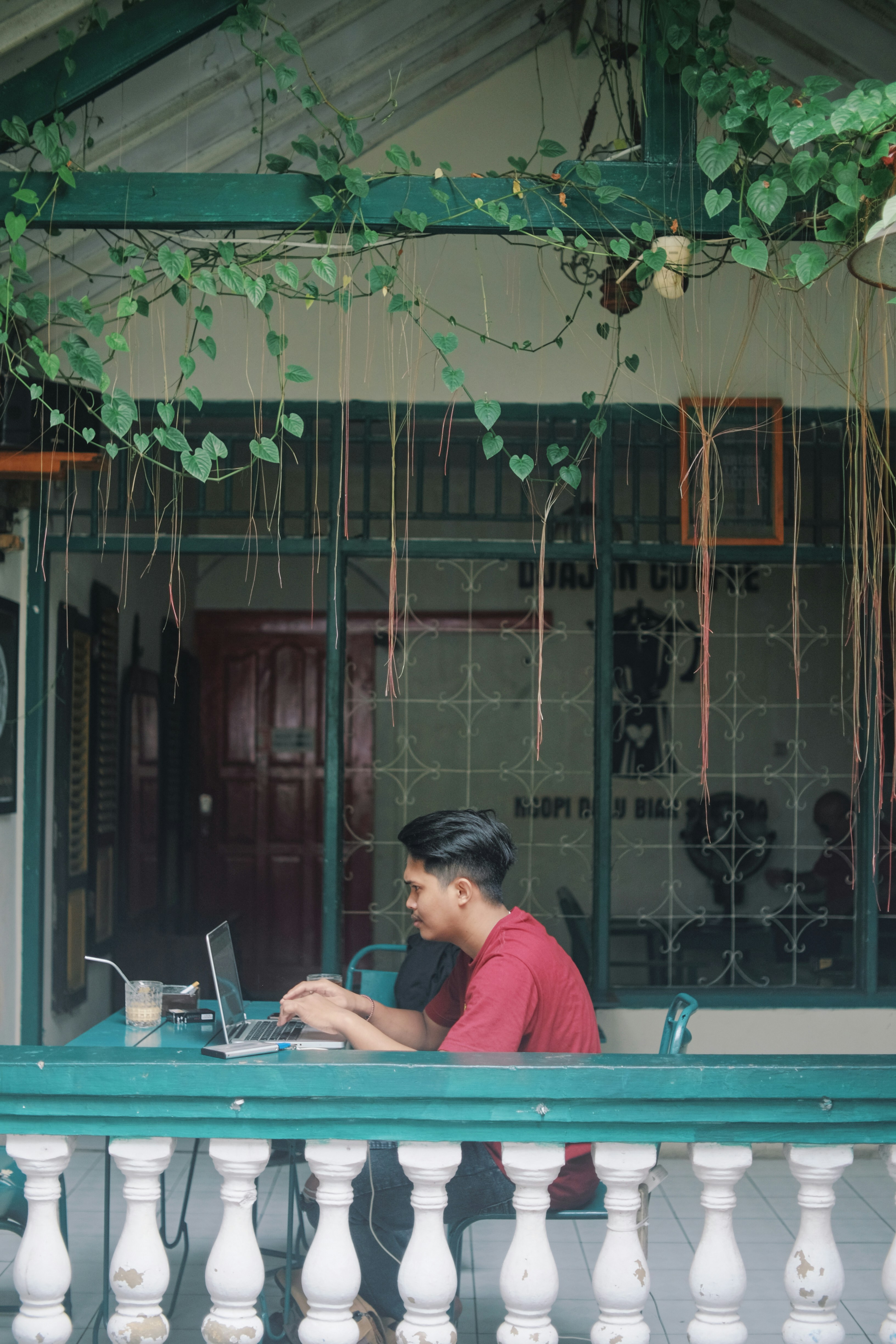 Quiet Focus: A Student at Work in a Verdant Balcony