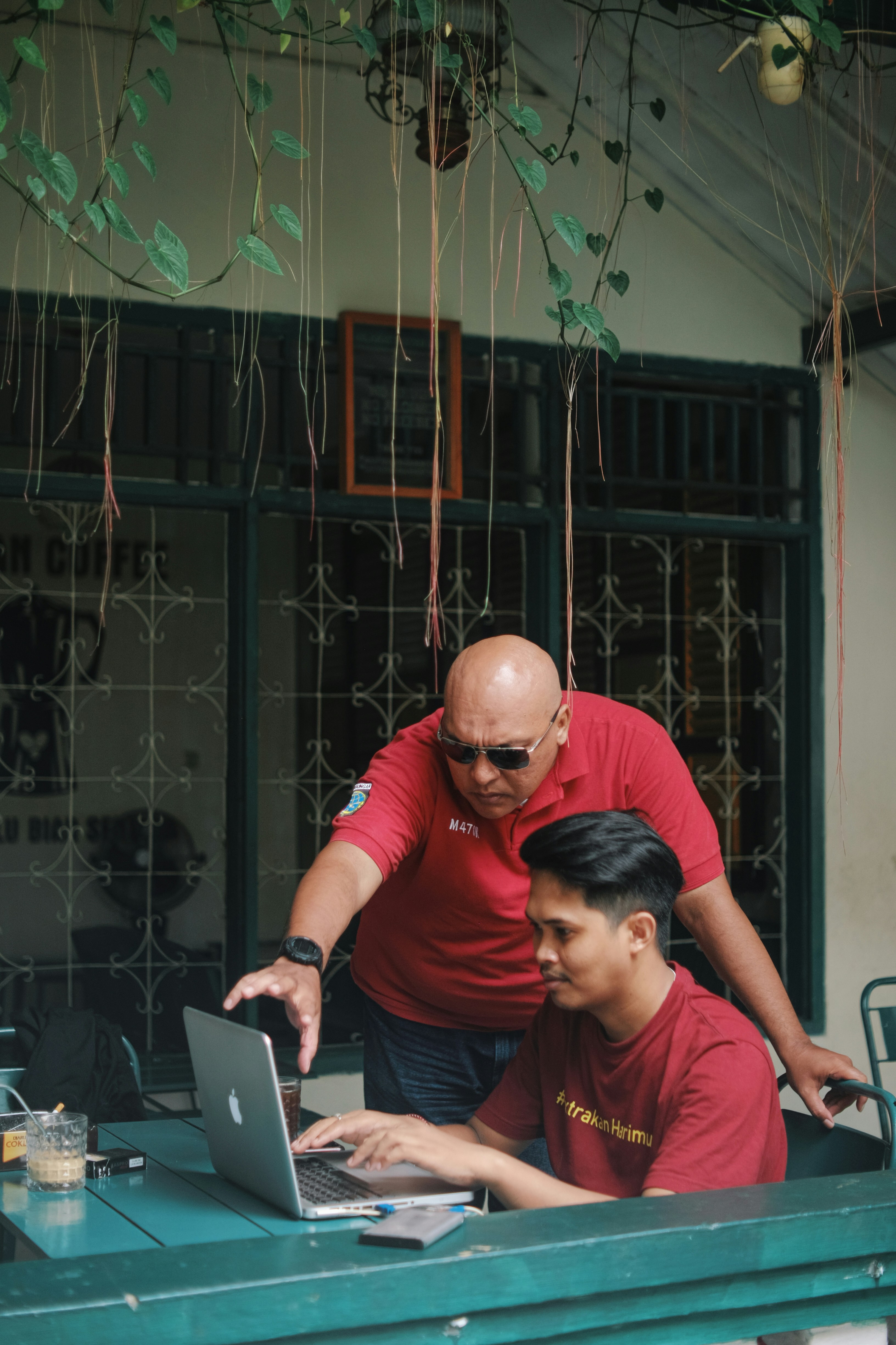 Vine-Wrapped Courtyard: Mentor Over the Shoulder with a Laptop