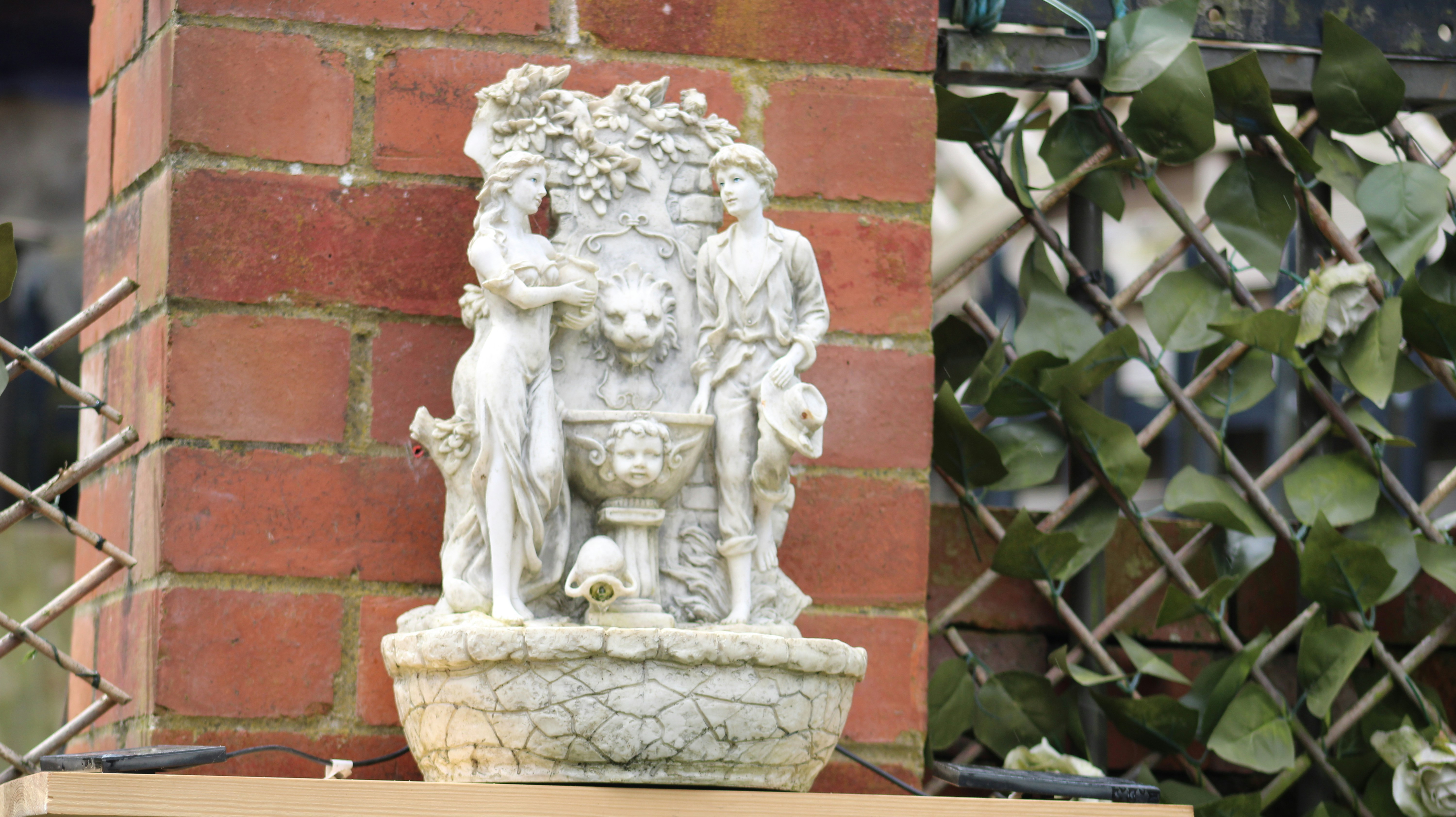 Stone Statue Garden Scene on Brick Balcony