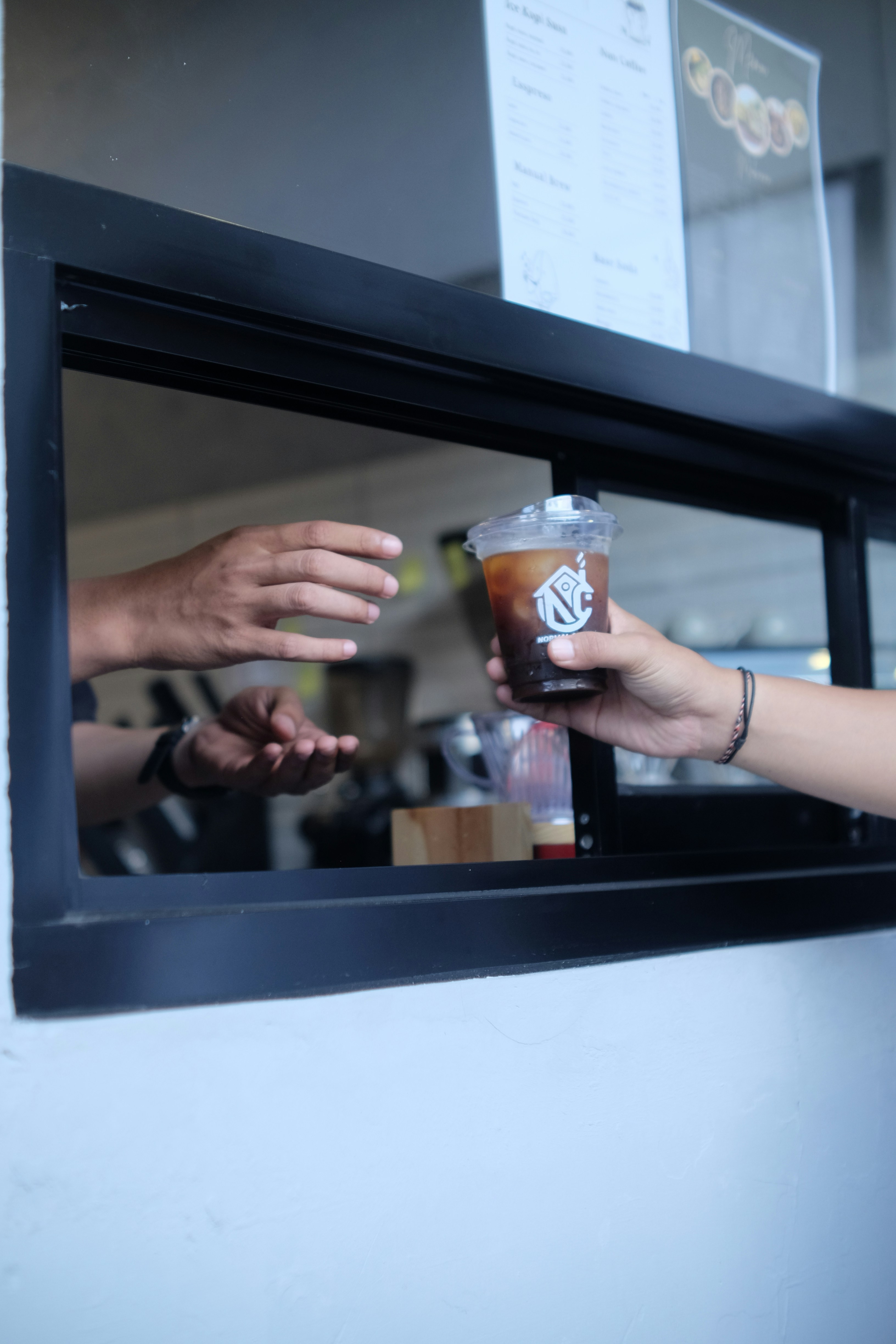 A person handing something to another person through a window photo ...