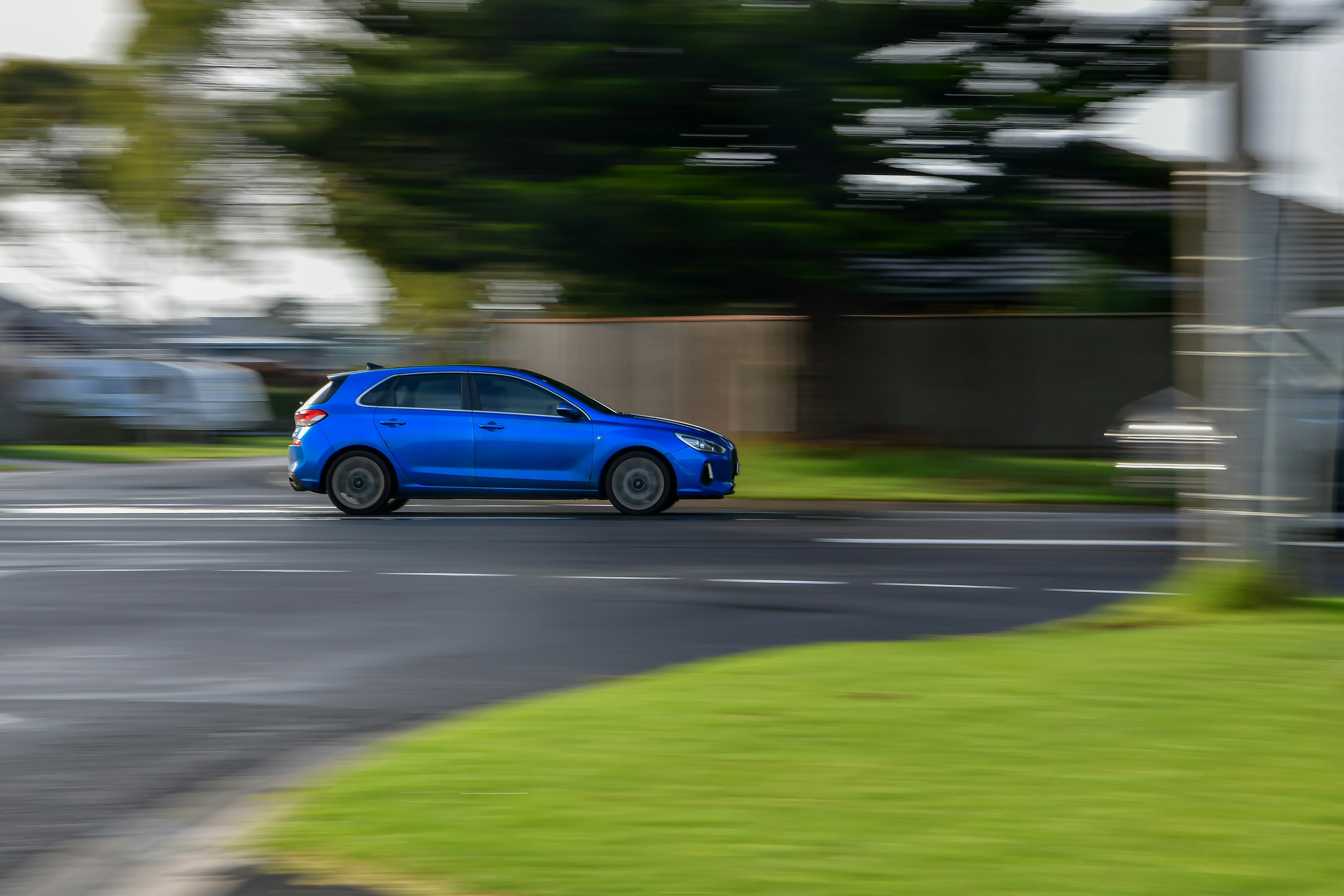 A small blue car driving down a street photo – Free Australia Image on ...