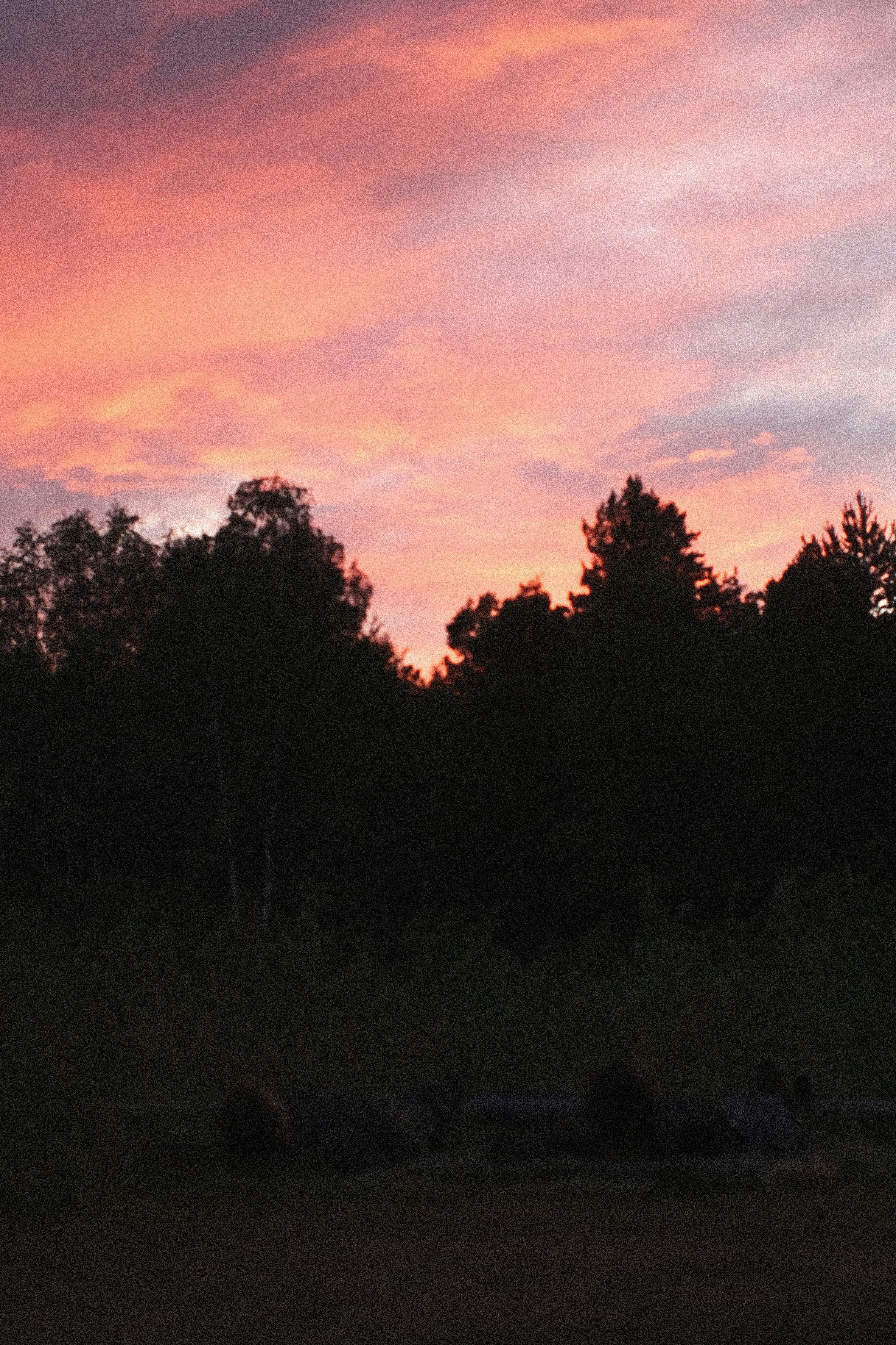 Sunset silhouette: calm horizon behind a darkened camp scene