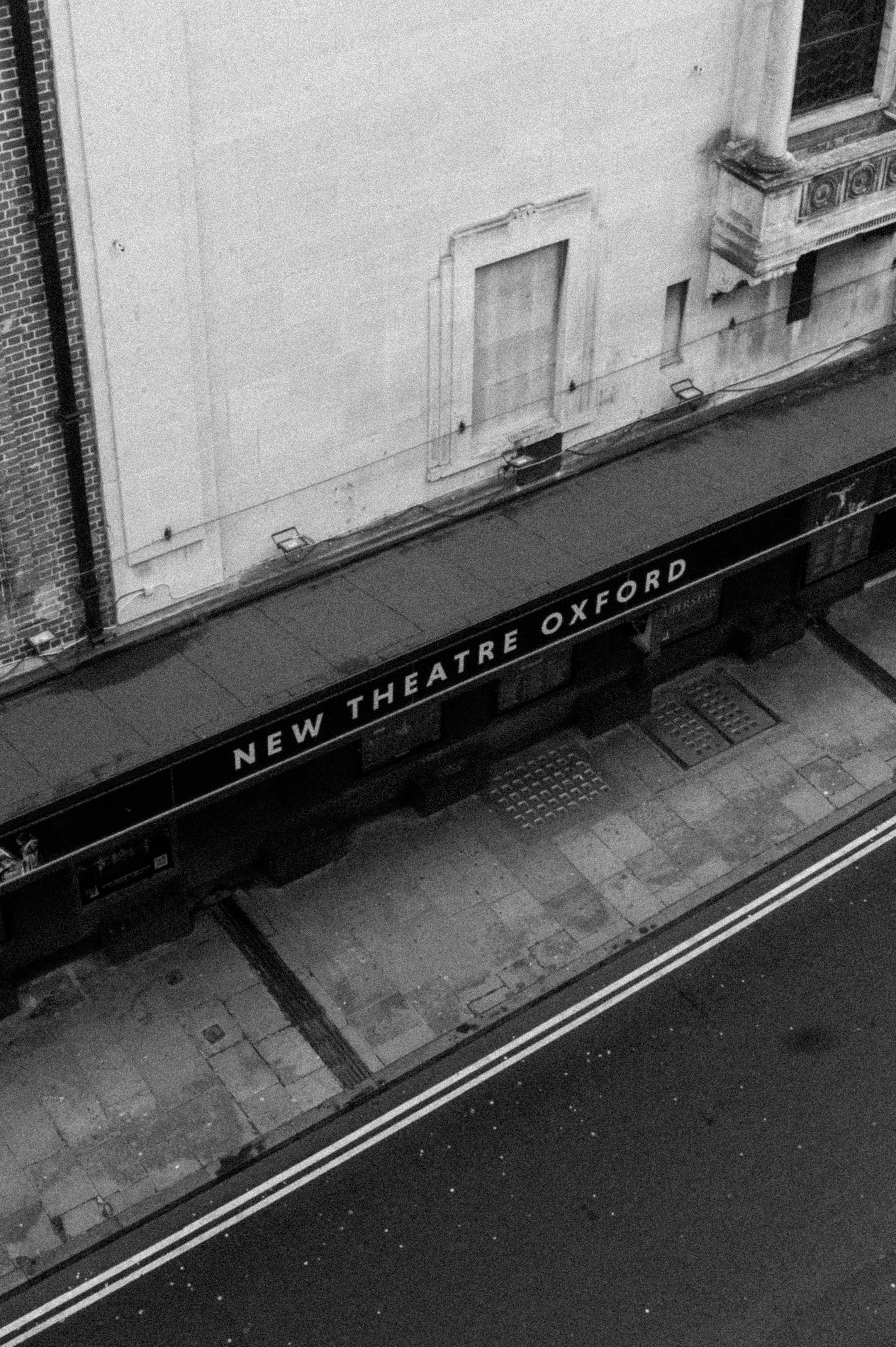 a black and white photo of a store on a street corner