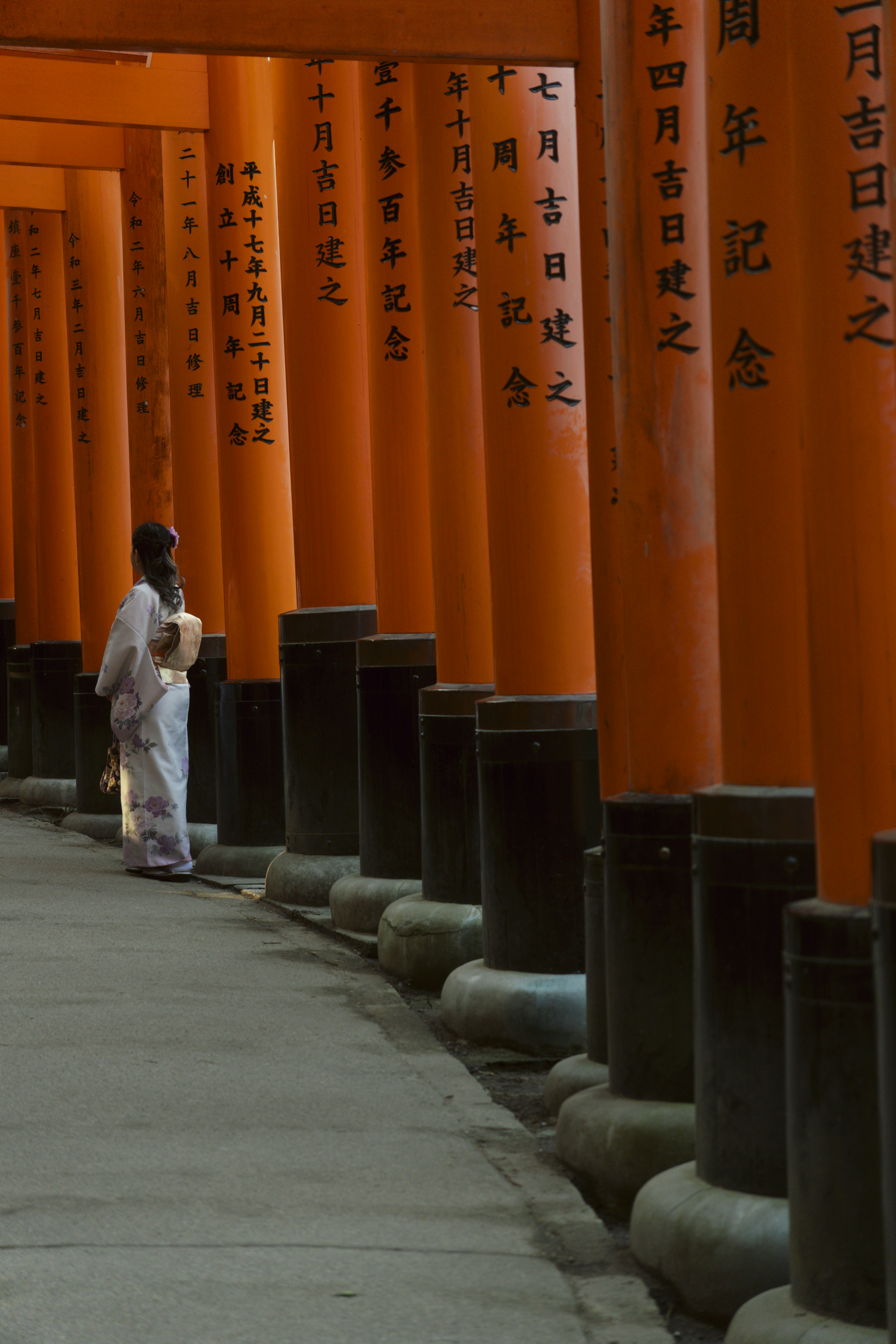 ⛩️⛩️⛩️ | a woman in a white kimono is standing in front of a row of orange