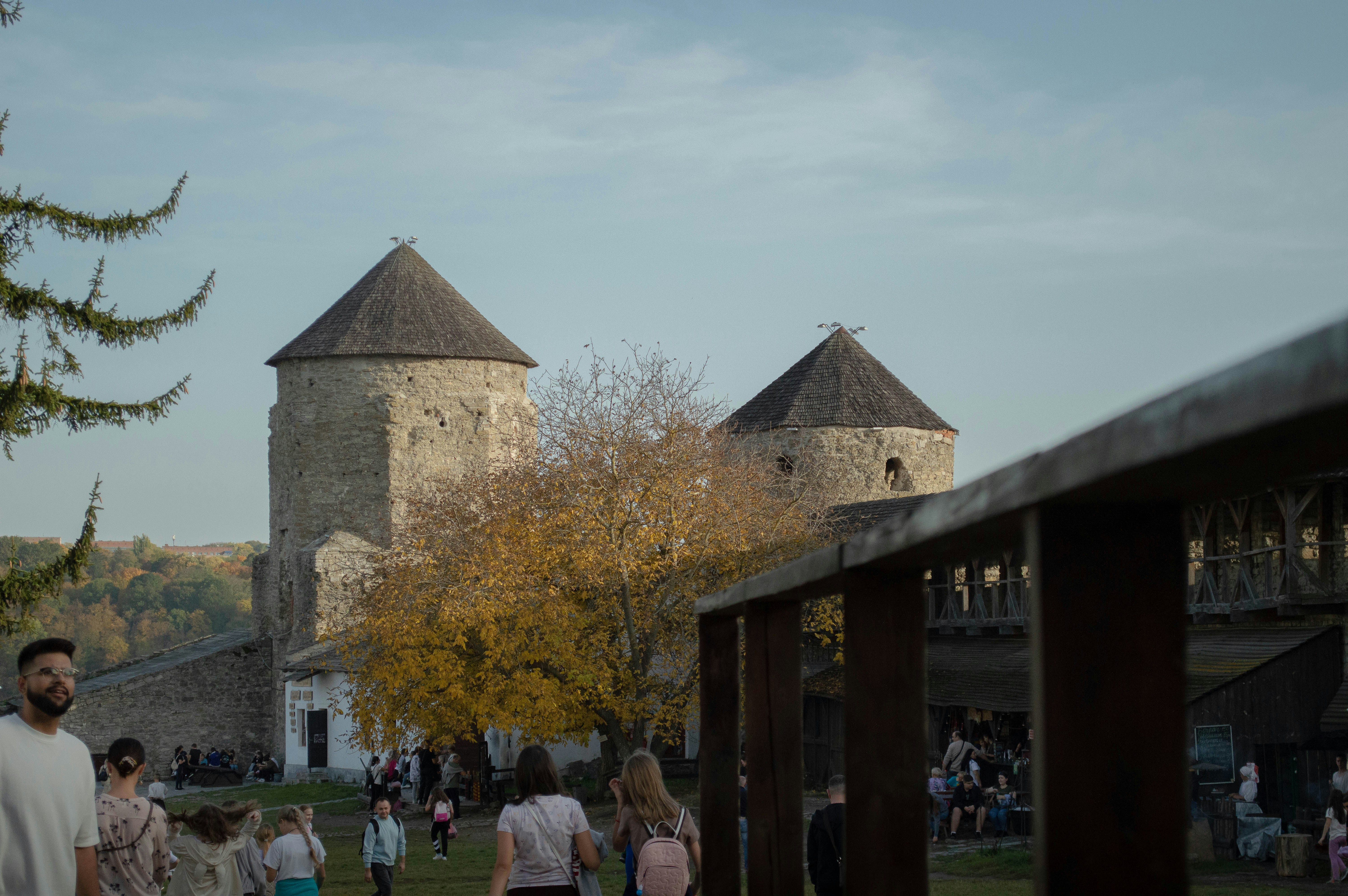 A group of people walking down a street next to a castle photo – Free Khmelnytskyi Image on Unsplash