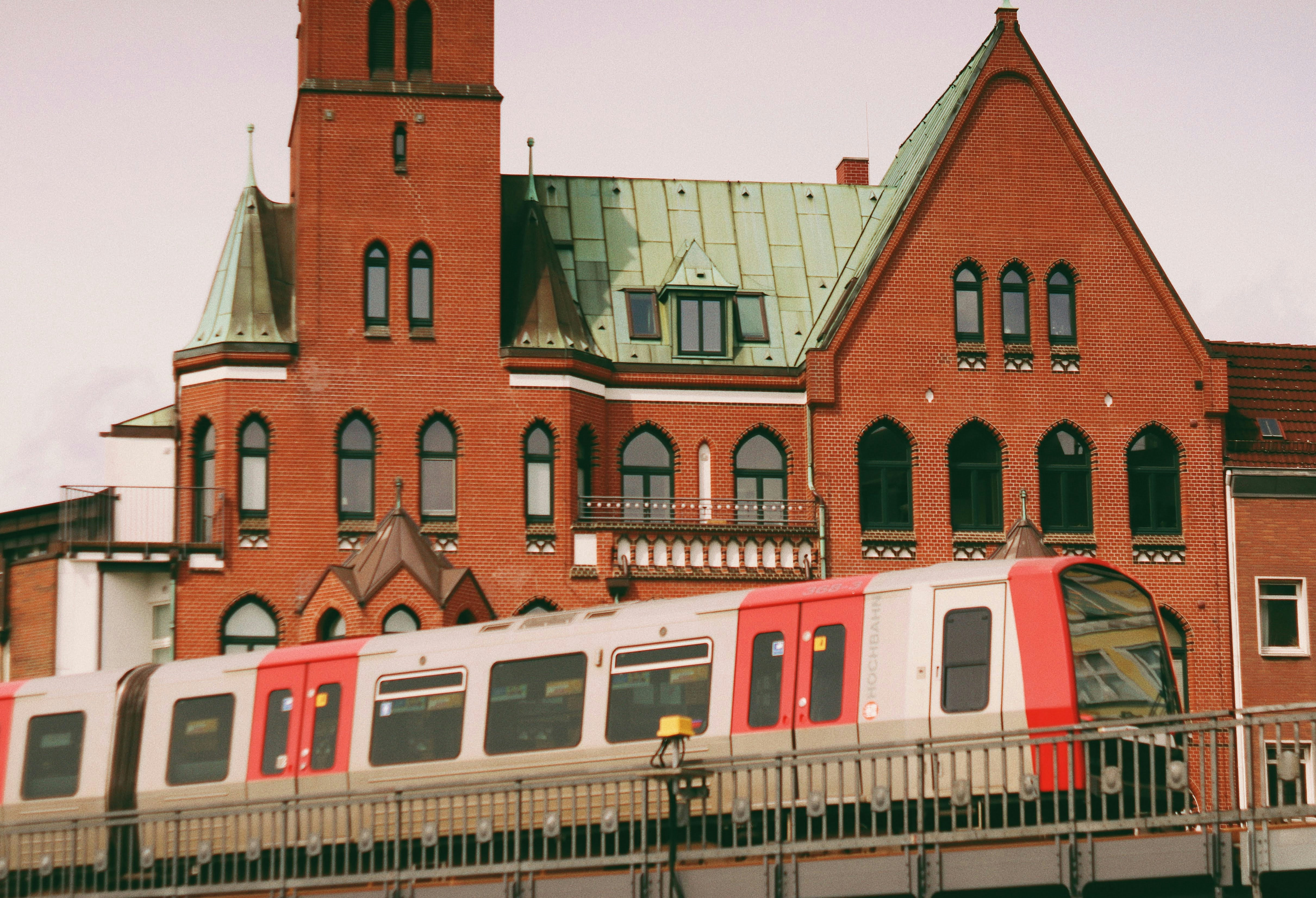 Red Train Slices Through a Brick-Castle Cityscape