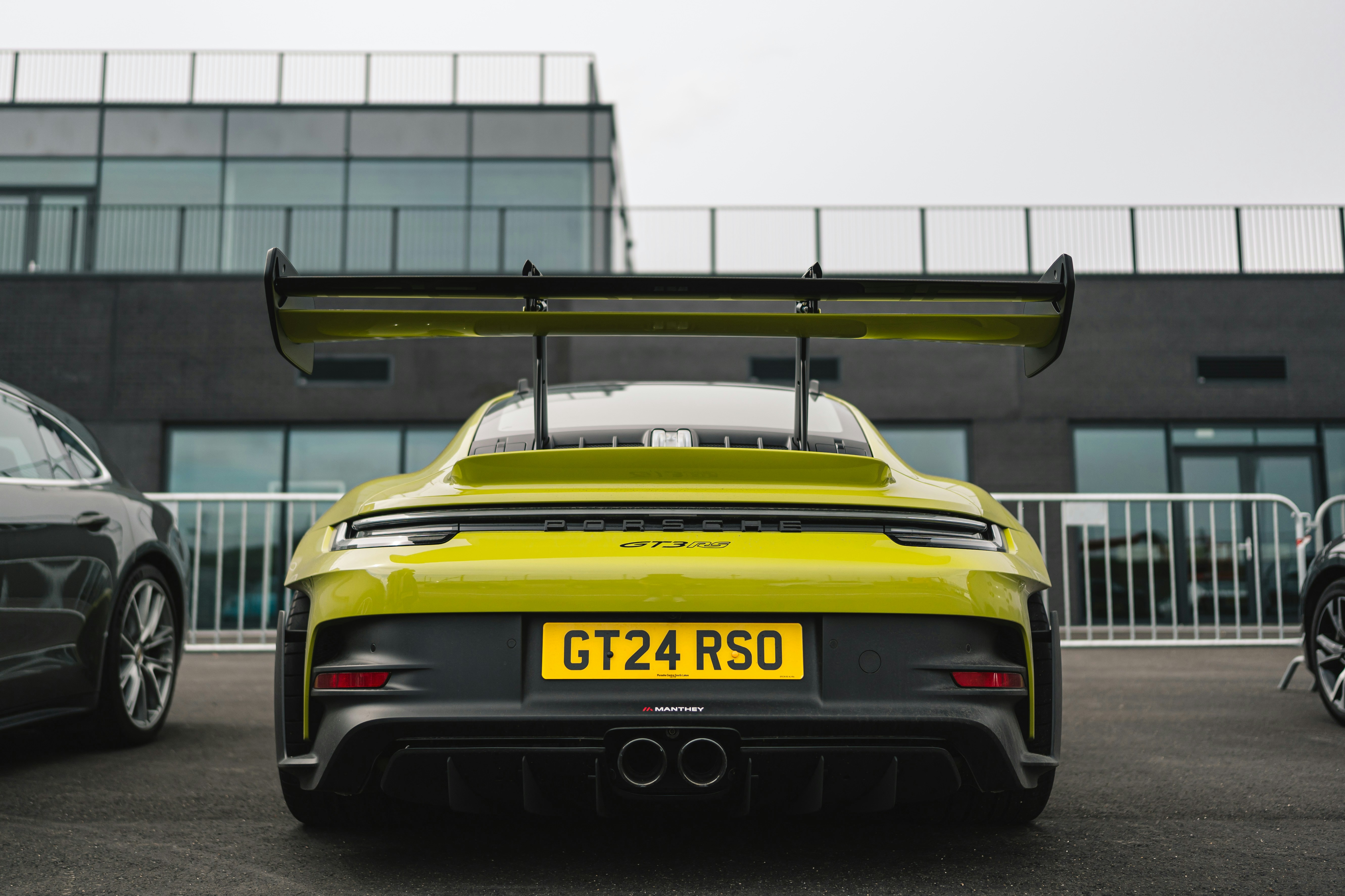 Neon-Green Porsche 911 GT3 RS: A Bold Rear View Framed by Glass Architecture