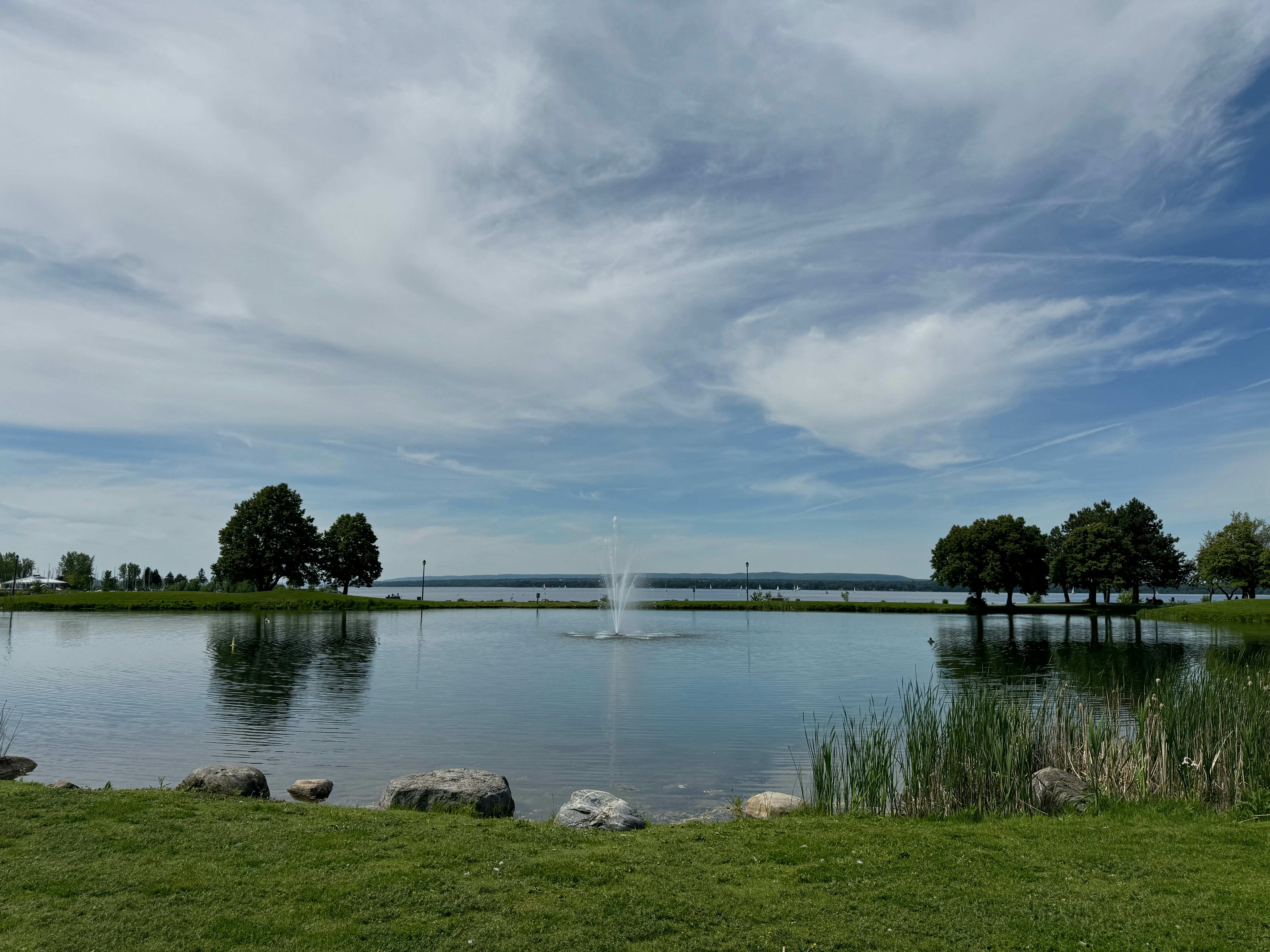 Quiet lakeside fountain under a vast sky