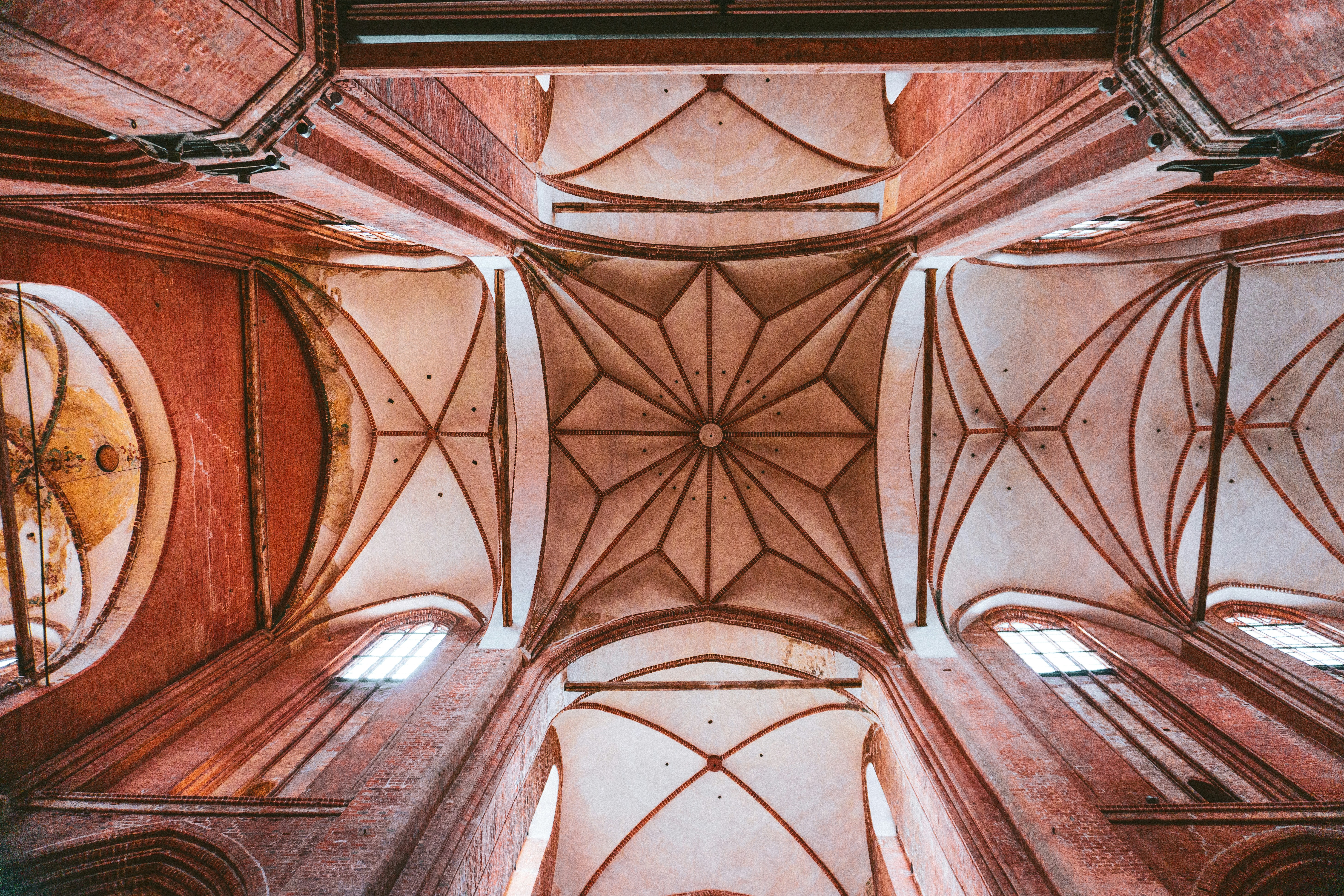 Gothic cathedral ceiling with symmetrical arches and detailed stonework captured from below.