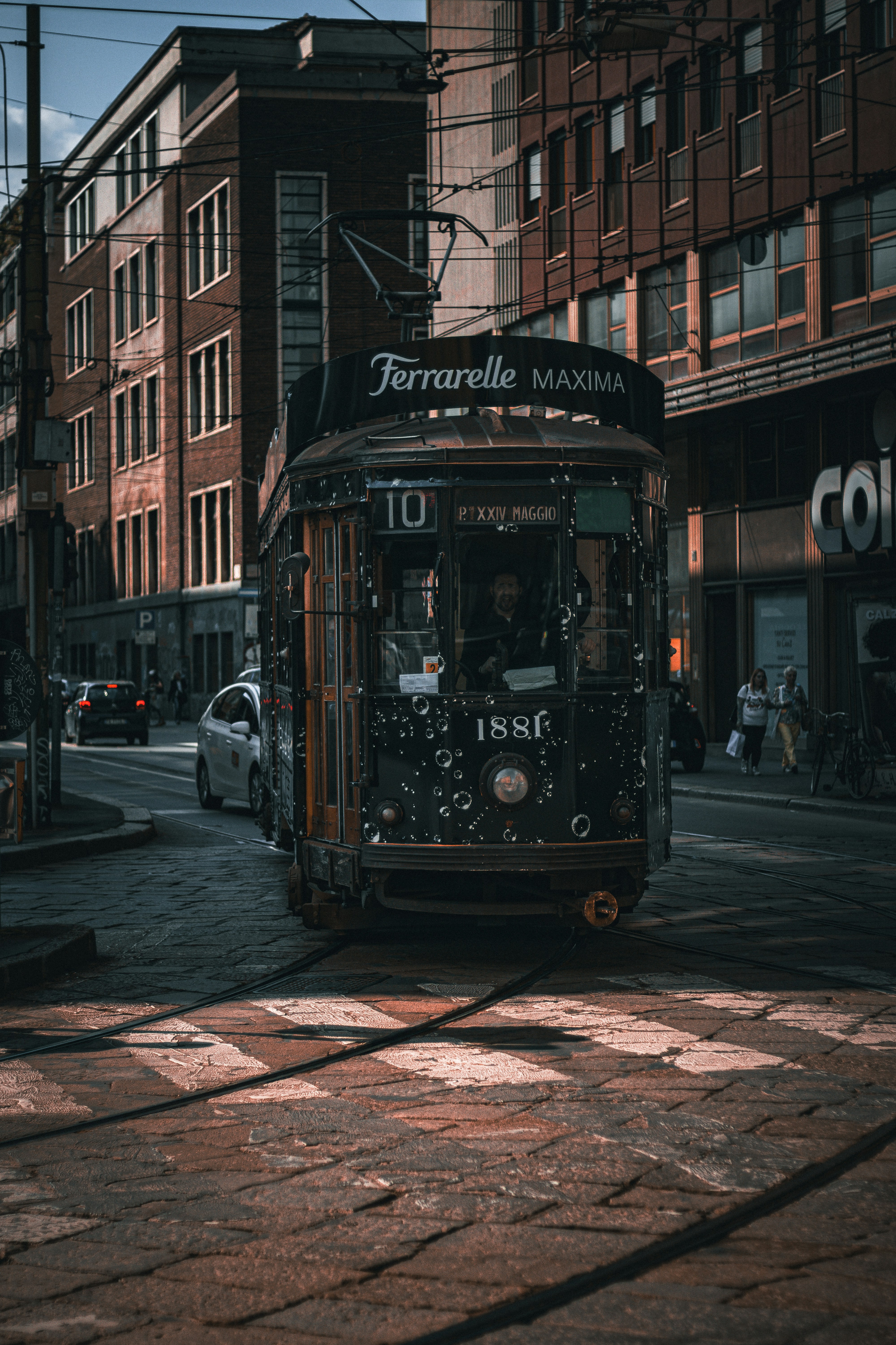 A trolley car on a city street with buildings in the background photo ...