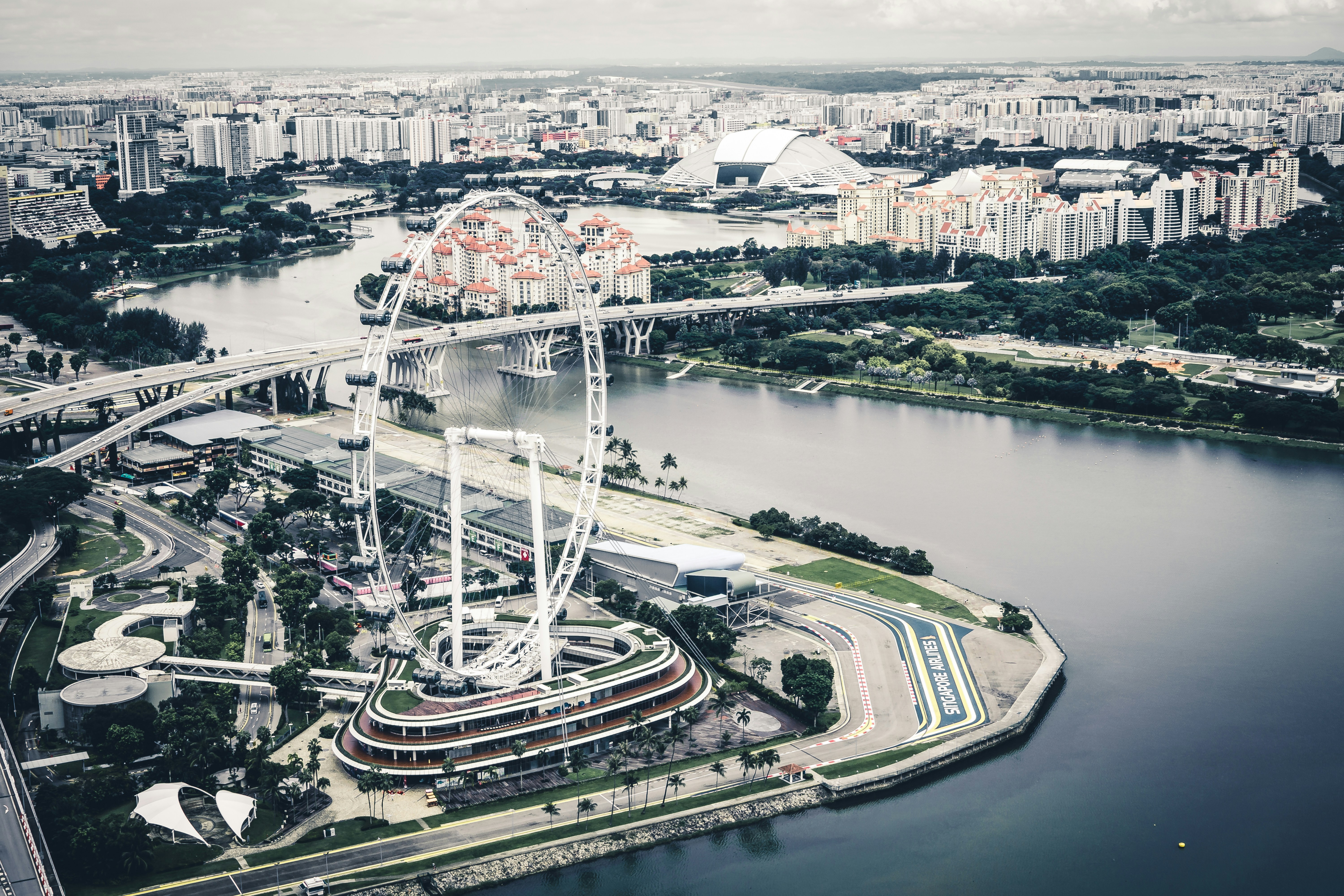 Riverside Ring: An Aerial Portrait of a Ferris Wheel and Circular Waterfront Pavilion