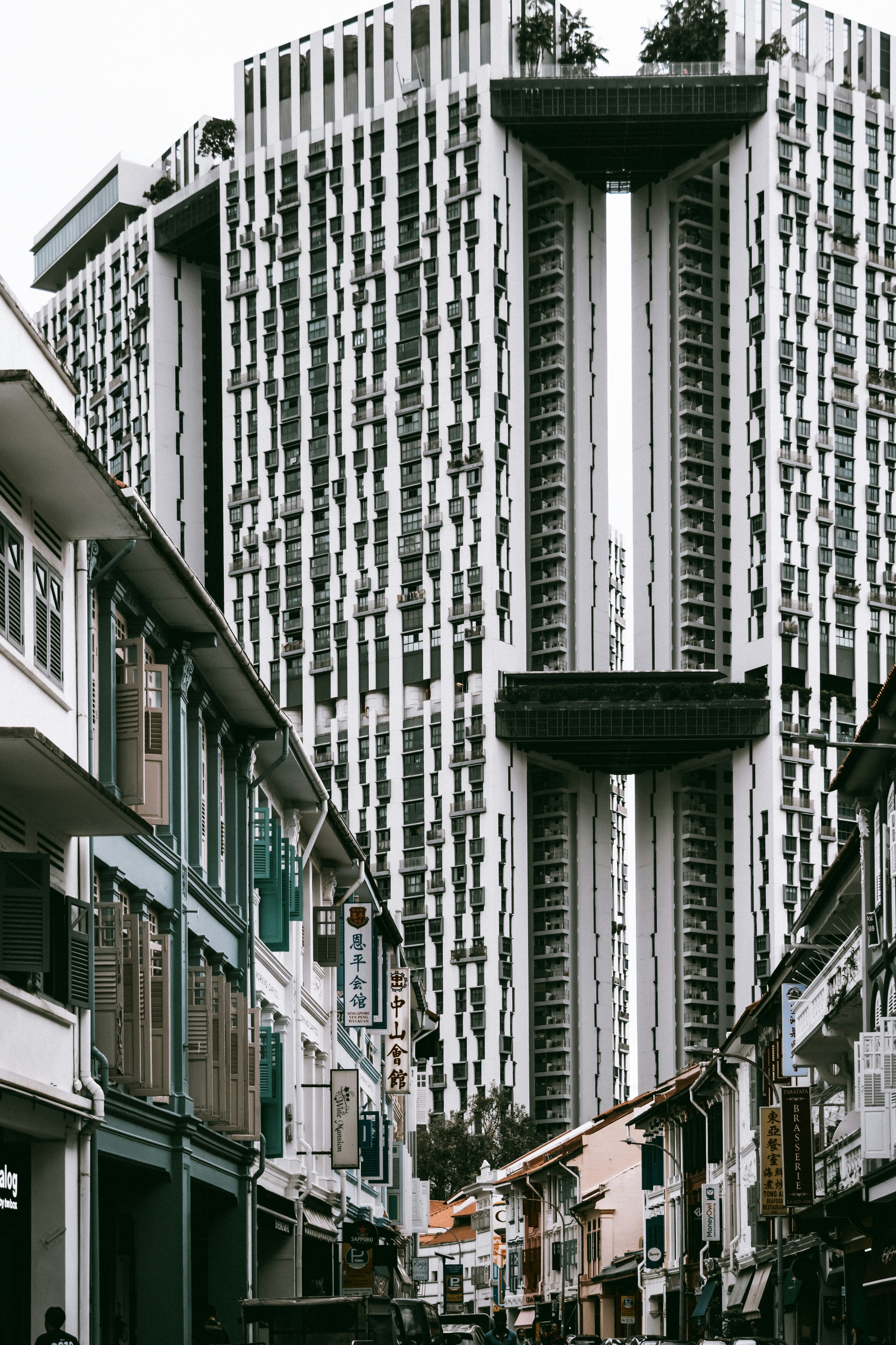 A group of people walking down a street next to tall buildings photo ...