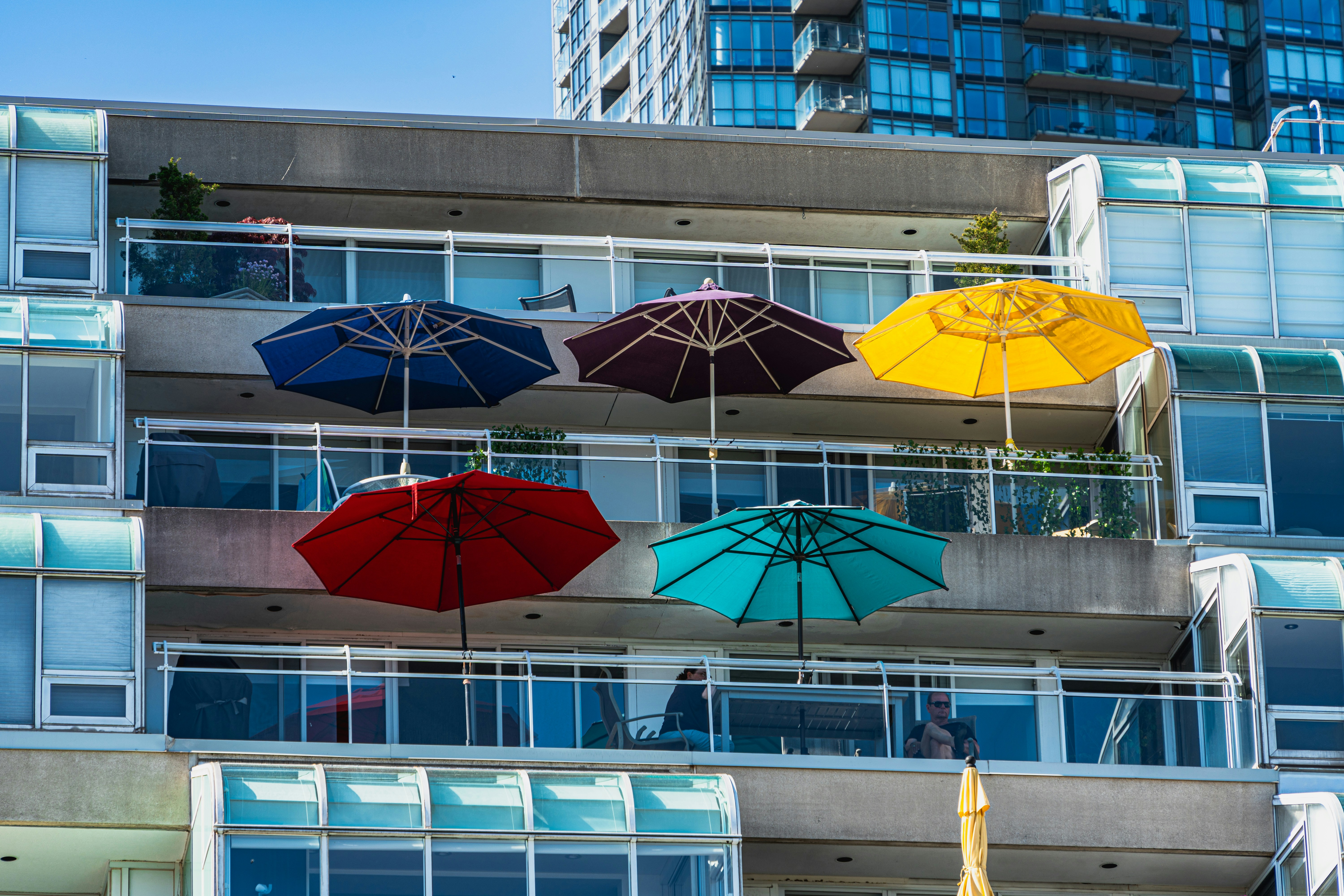 A group of colorful umbrellas hanging from a building photo – Free ...