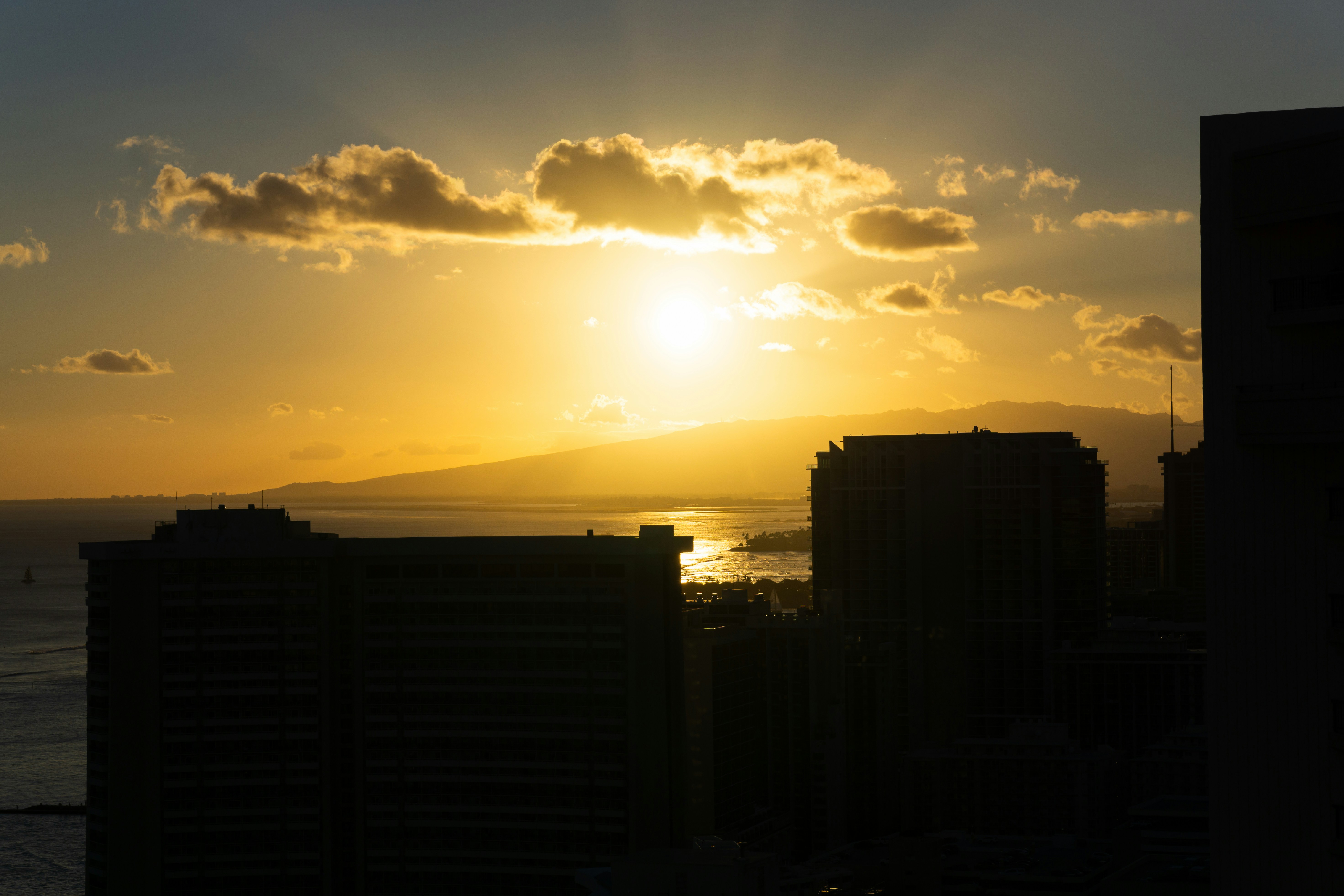 Horizon Halos: Dusk Silhouette Over Ocean and City Towers