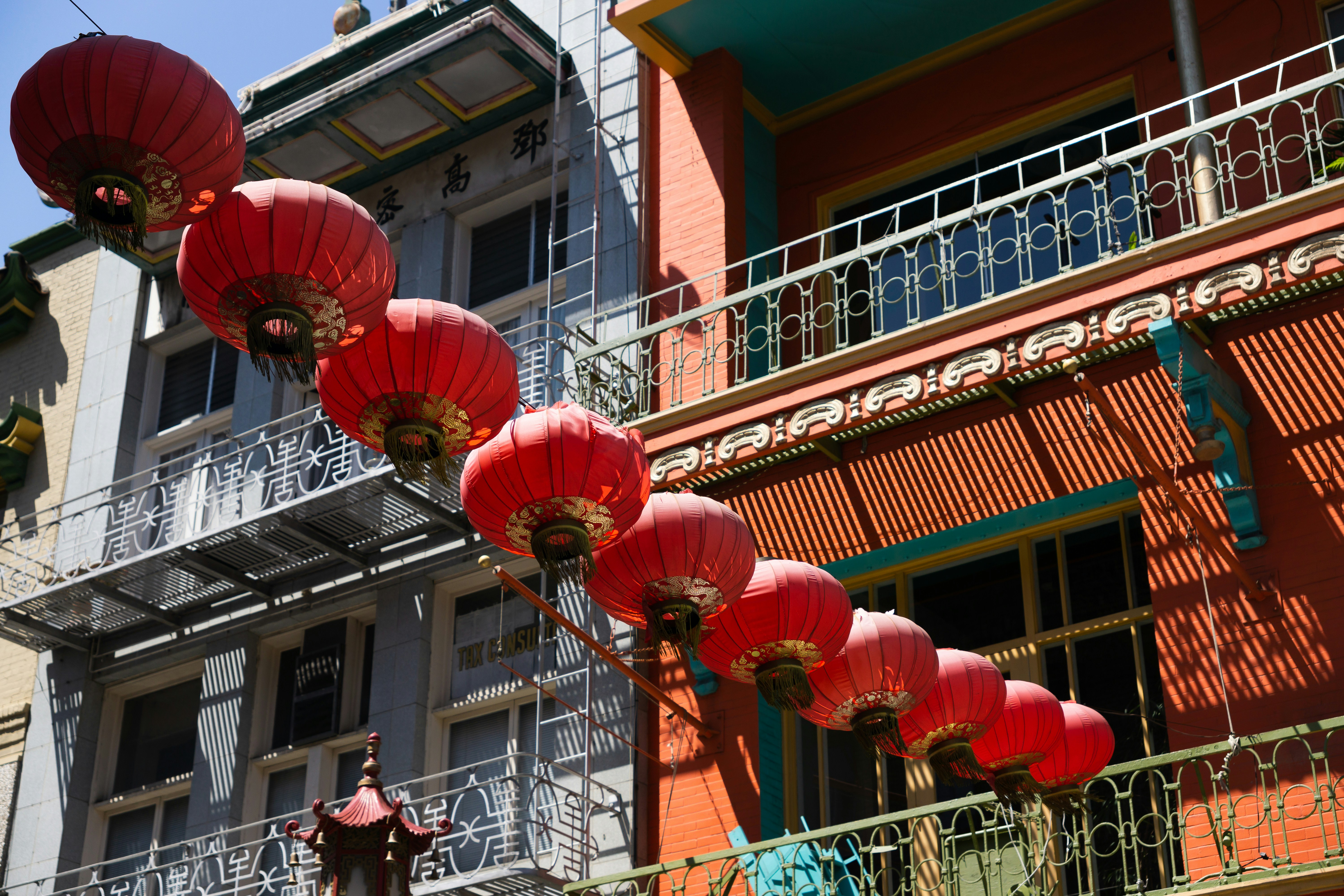 Red Lanterns Swing Along a Colorful Balcony