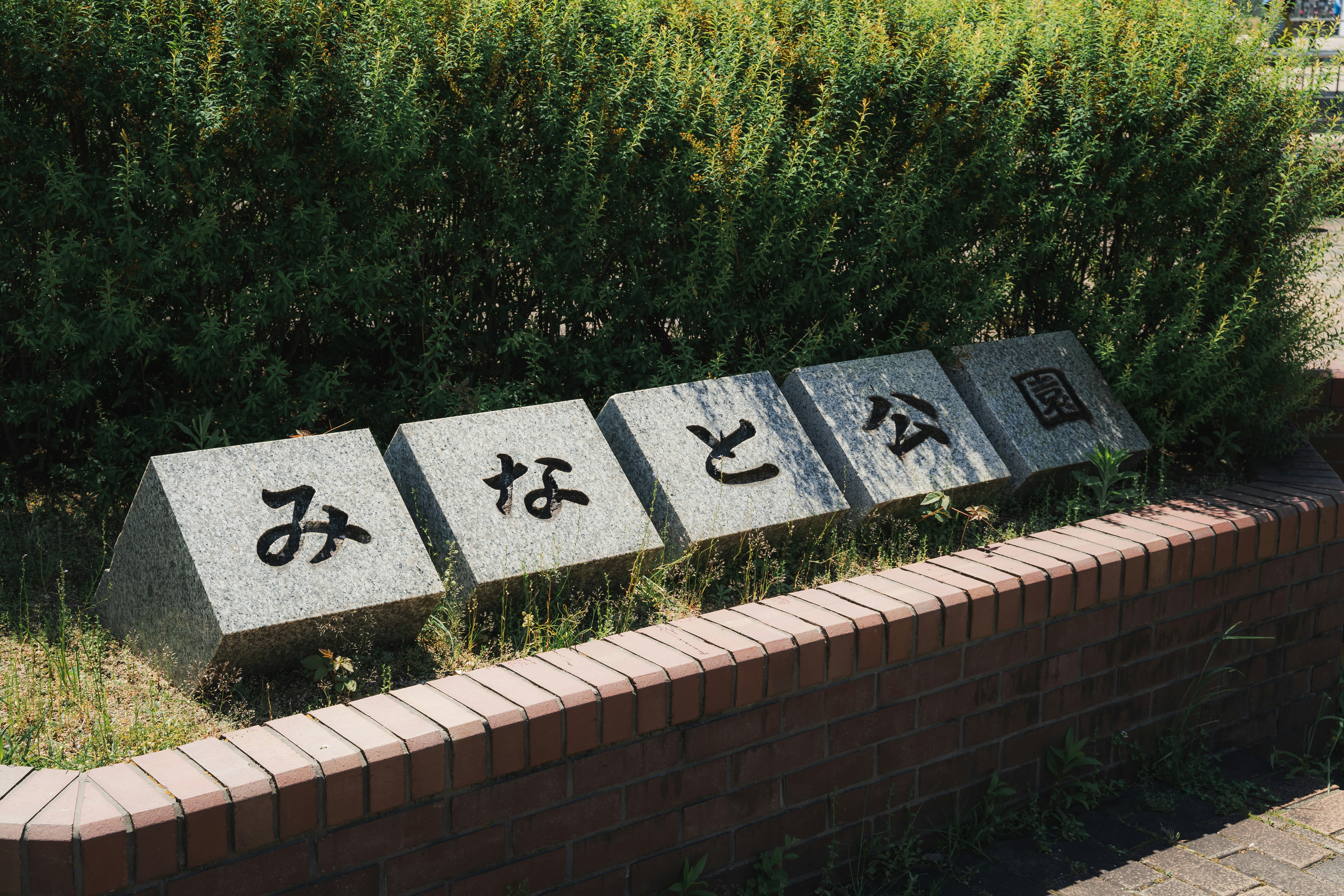 A brick wall with three stone signs on it photo – Free Japan Image on ...