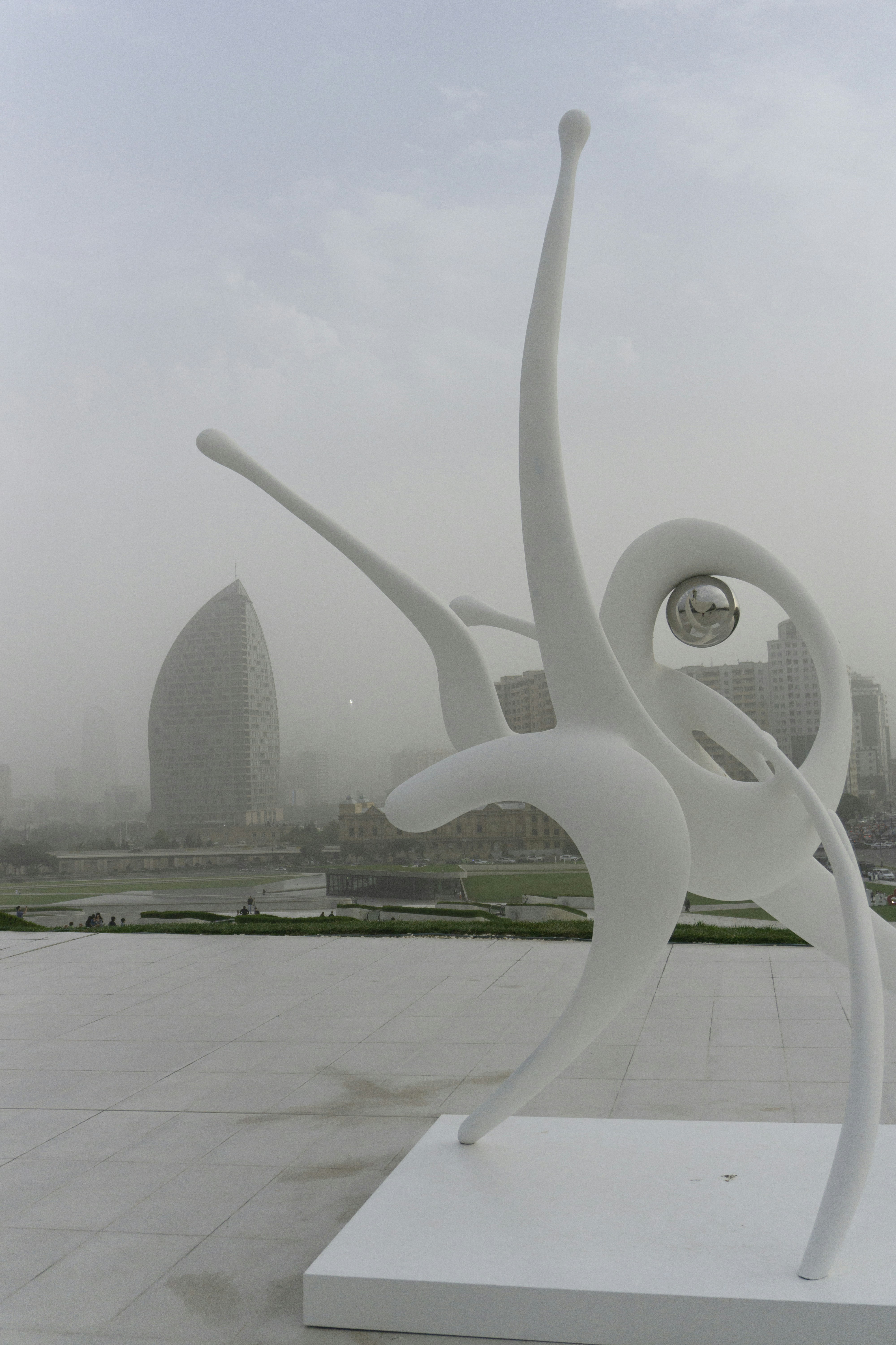 Arcs in the Haze: A White Sculpture Framing a Quiet Skyline