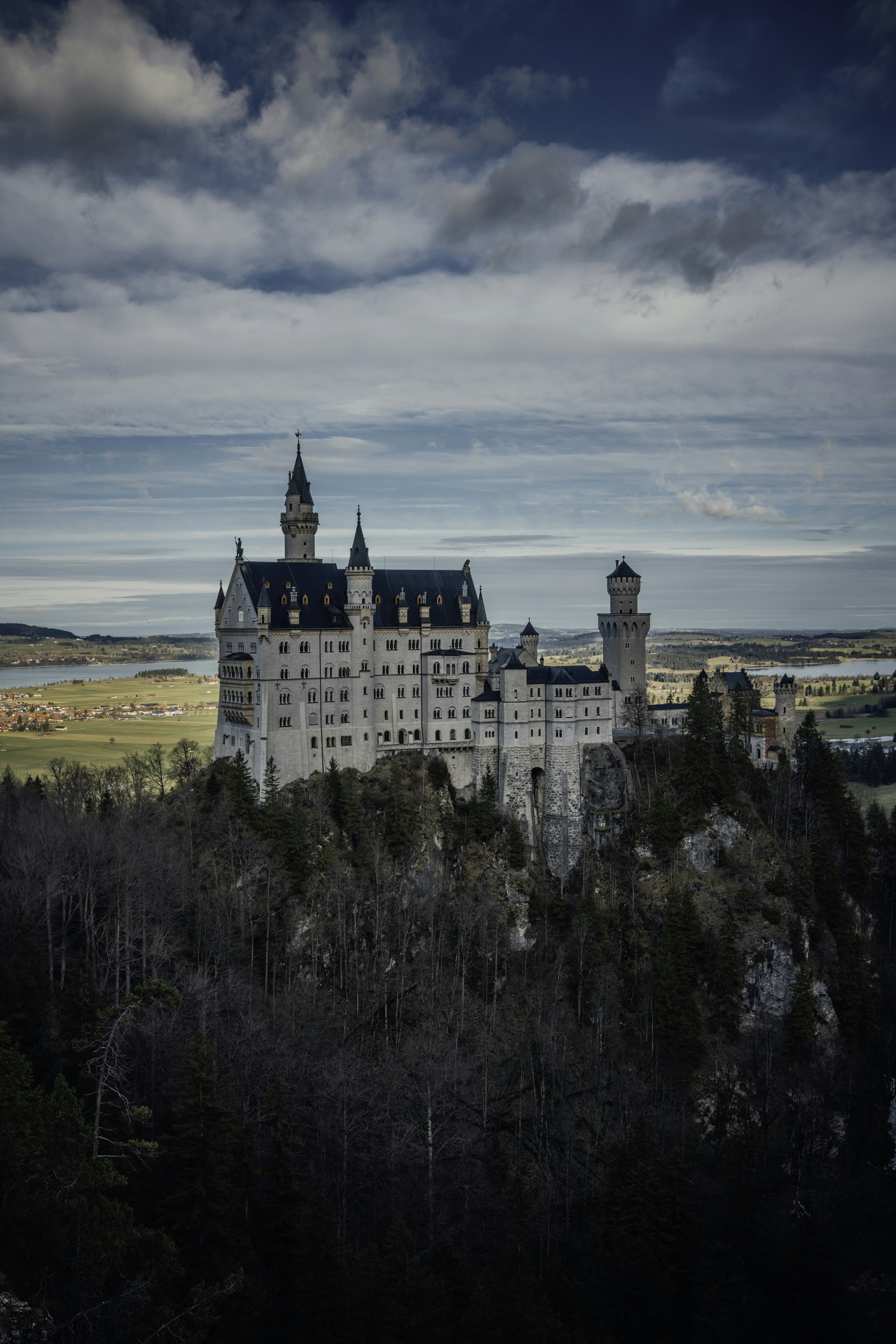 A large white castle sitting on top of a lush green hillside photo ...