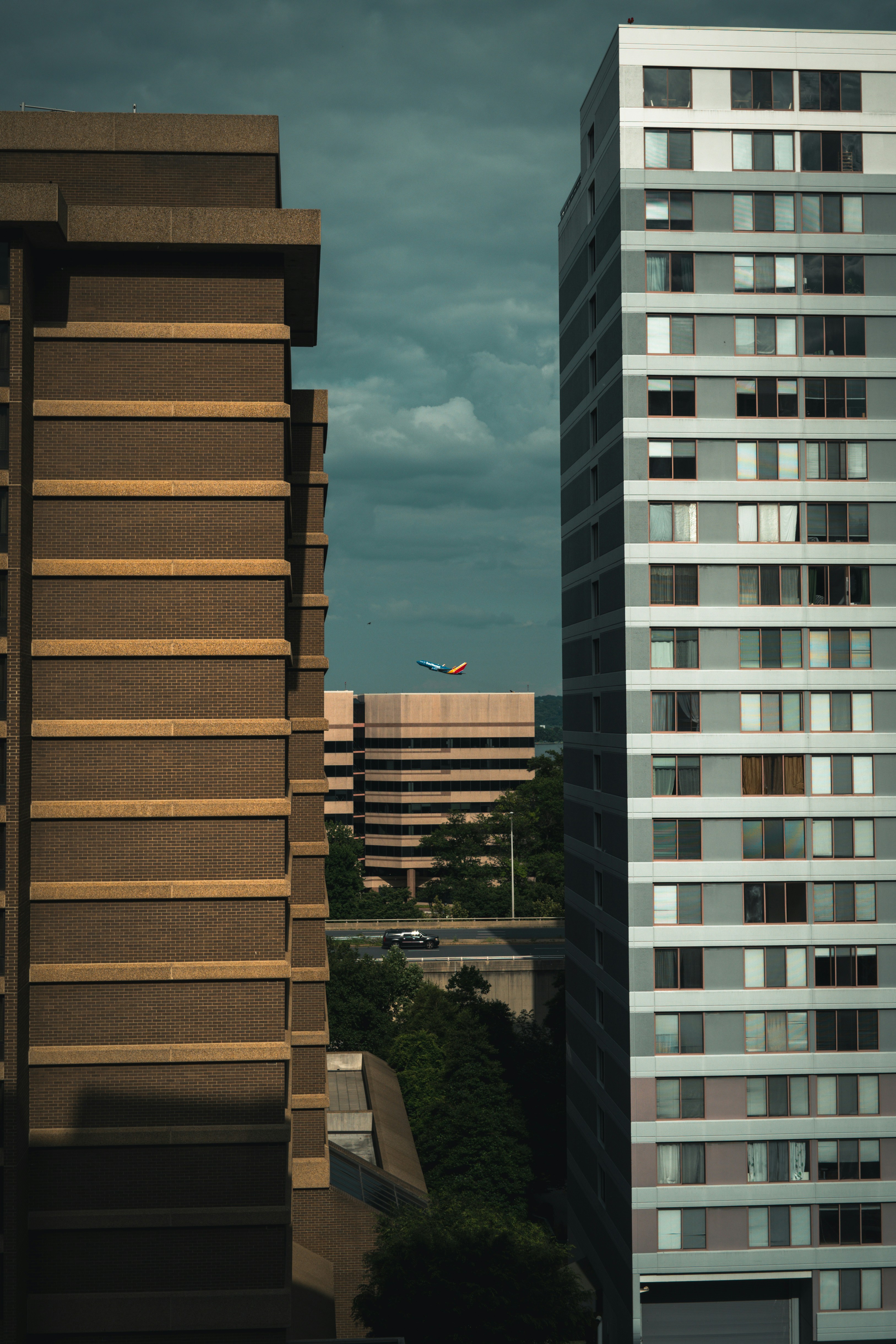 Jet Between Giants: Distant Airliner Framing a City Canyon