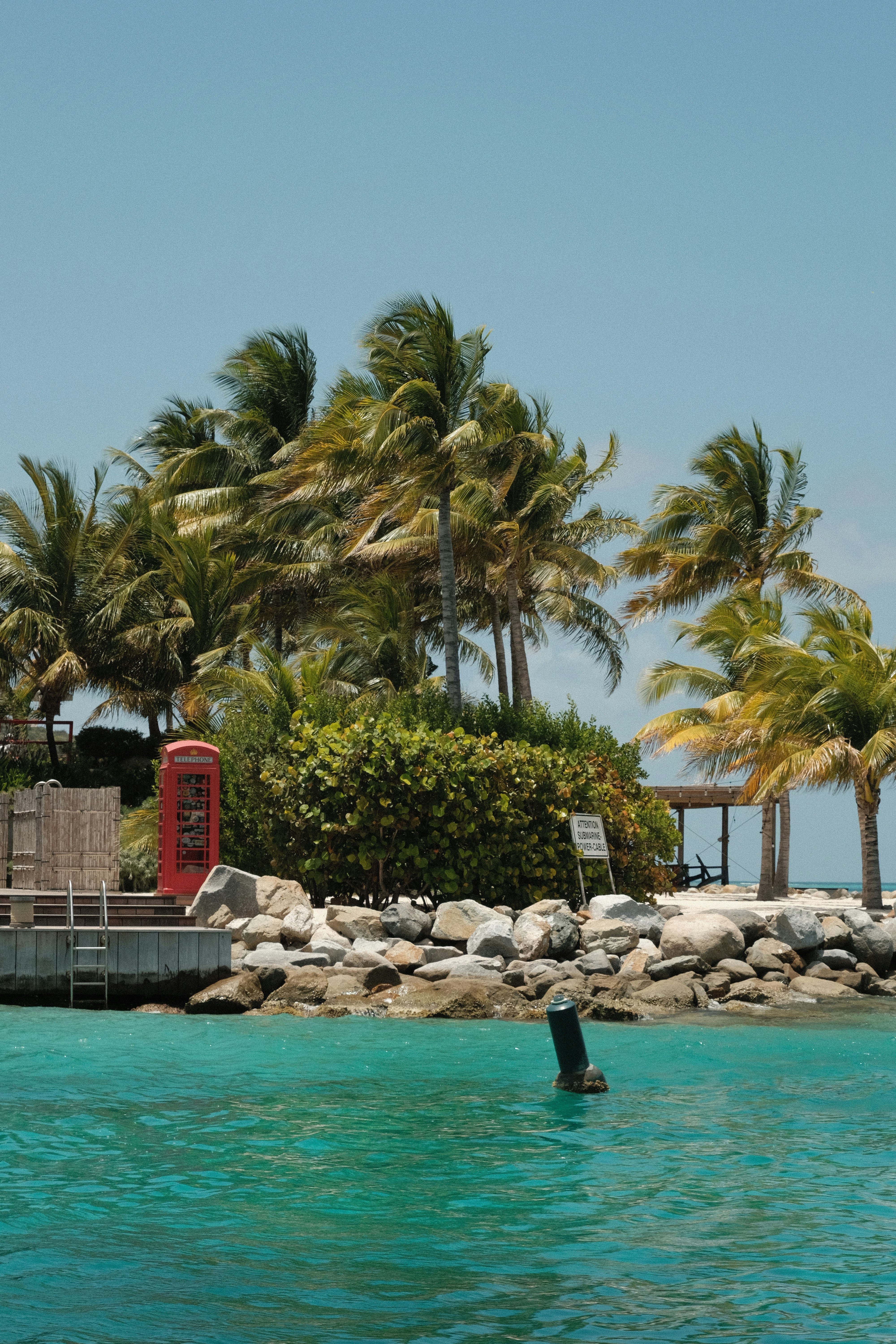 Red Telephone Booth Anchoring a Turquoise Caribbean Shoreline