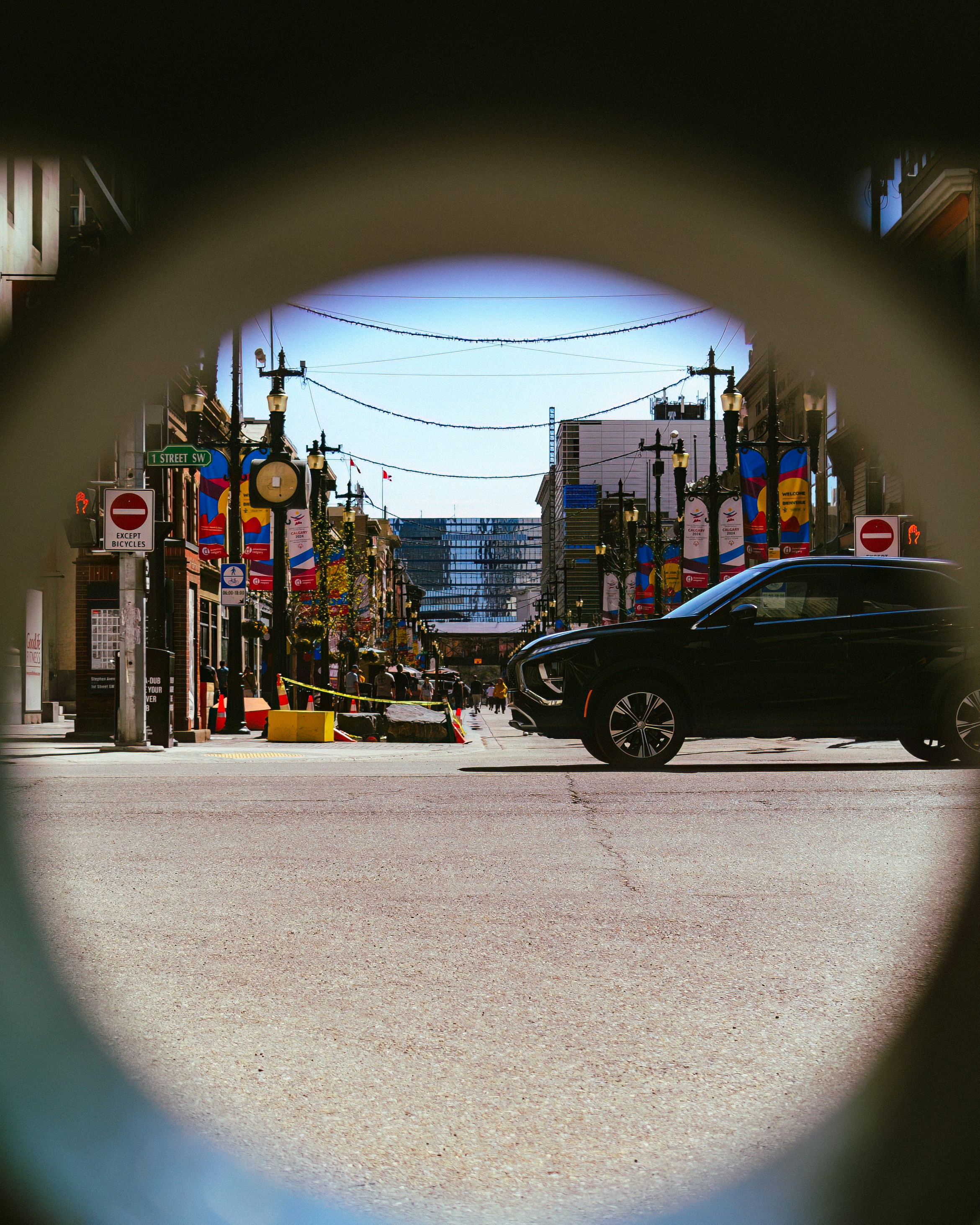 Through a Circular Frame: A Bannered Downtown Street Reaches the Horizon