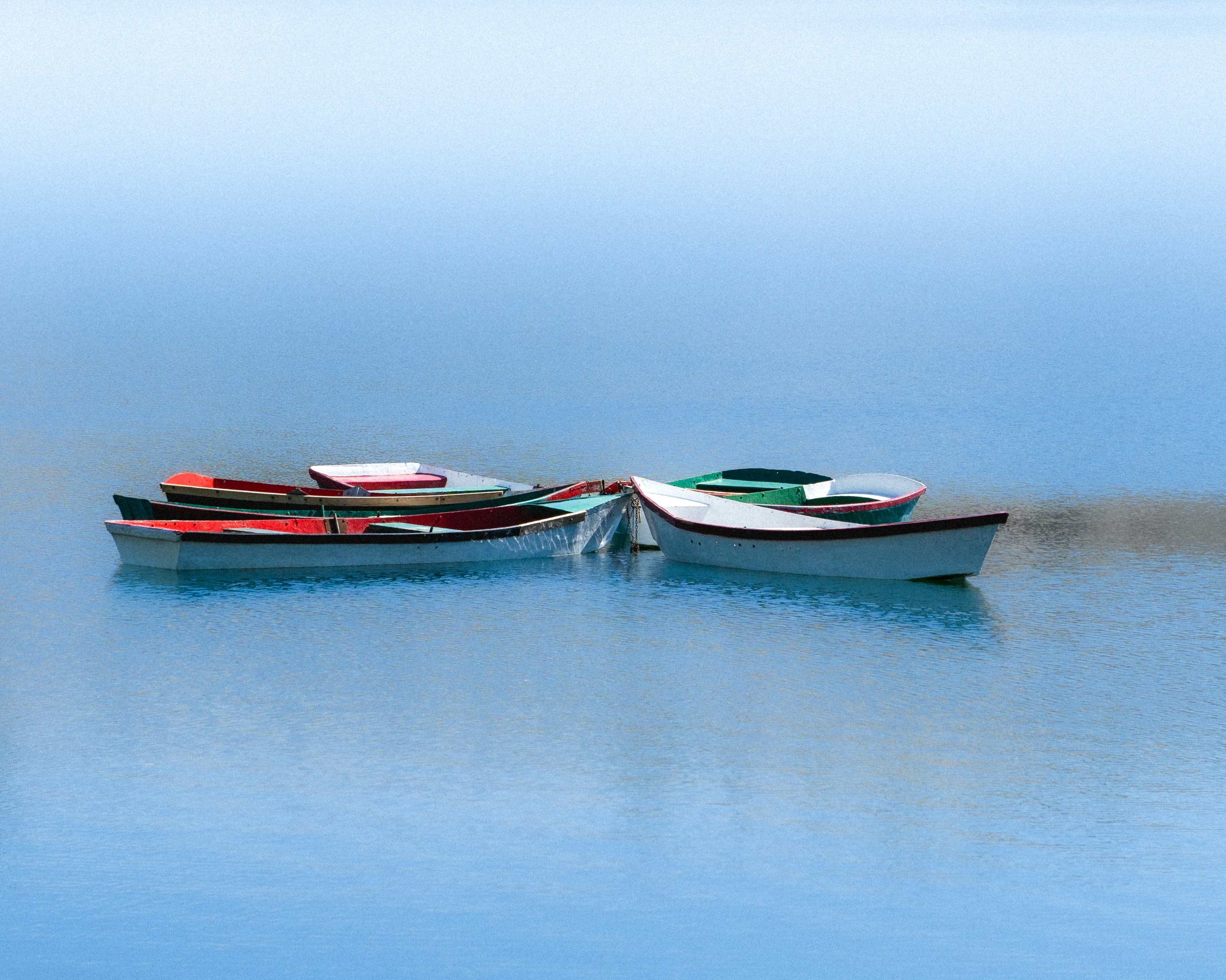 Cerulean Quiet: Four Dinghies Rest in a Glassy Sea