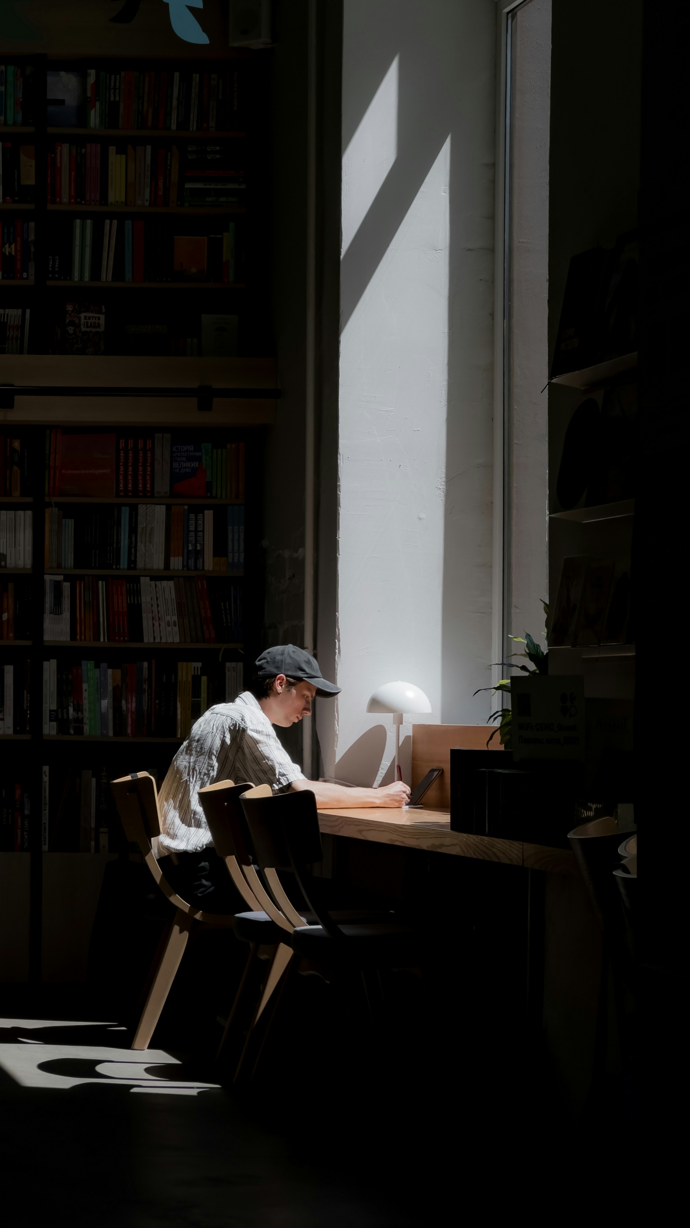 A man sitting at a desk in a dark room photo – Free Grey Image on Unsplash
