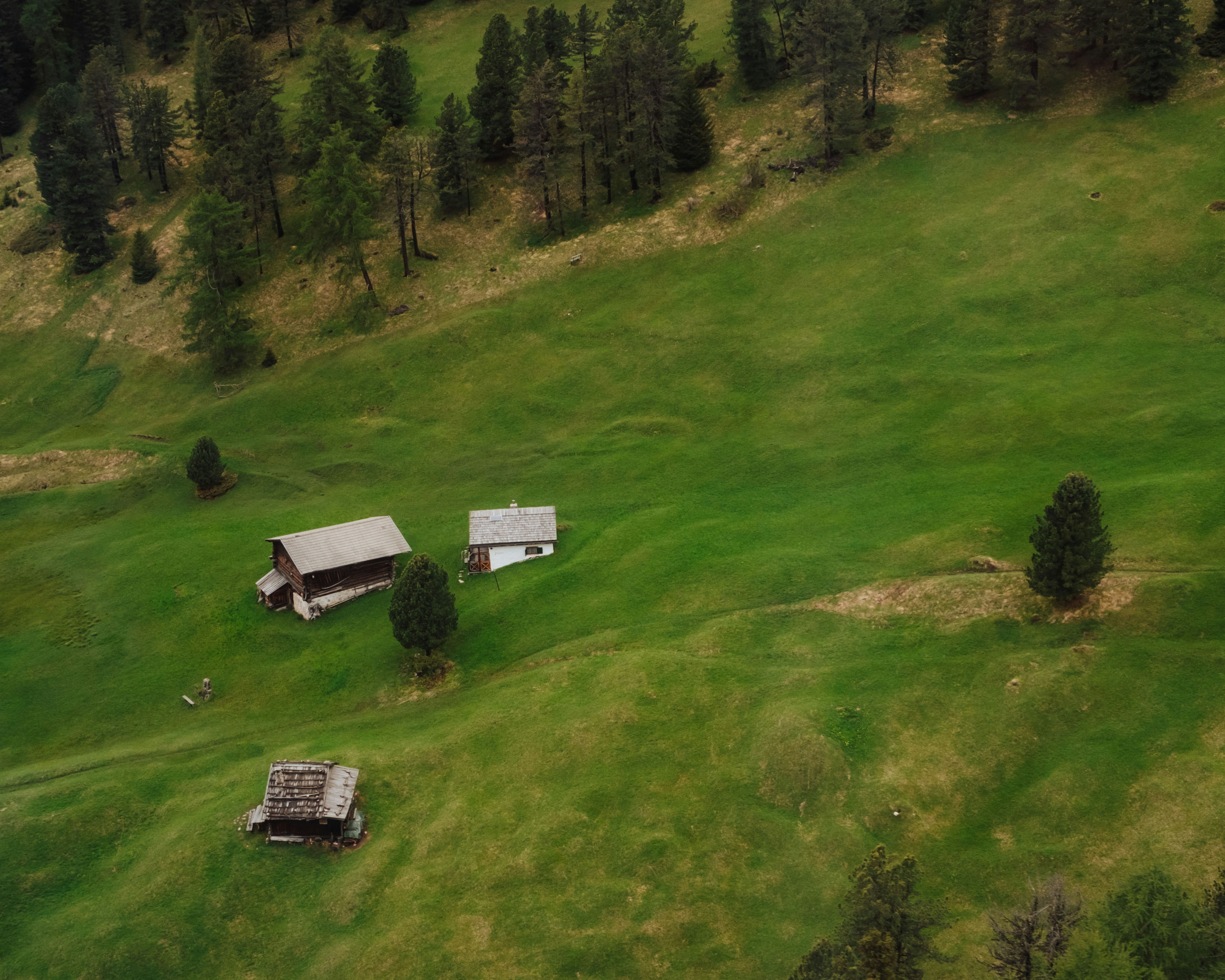 An aerial view of a grassy field with two cabins photo – Free Travel ...