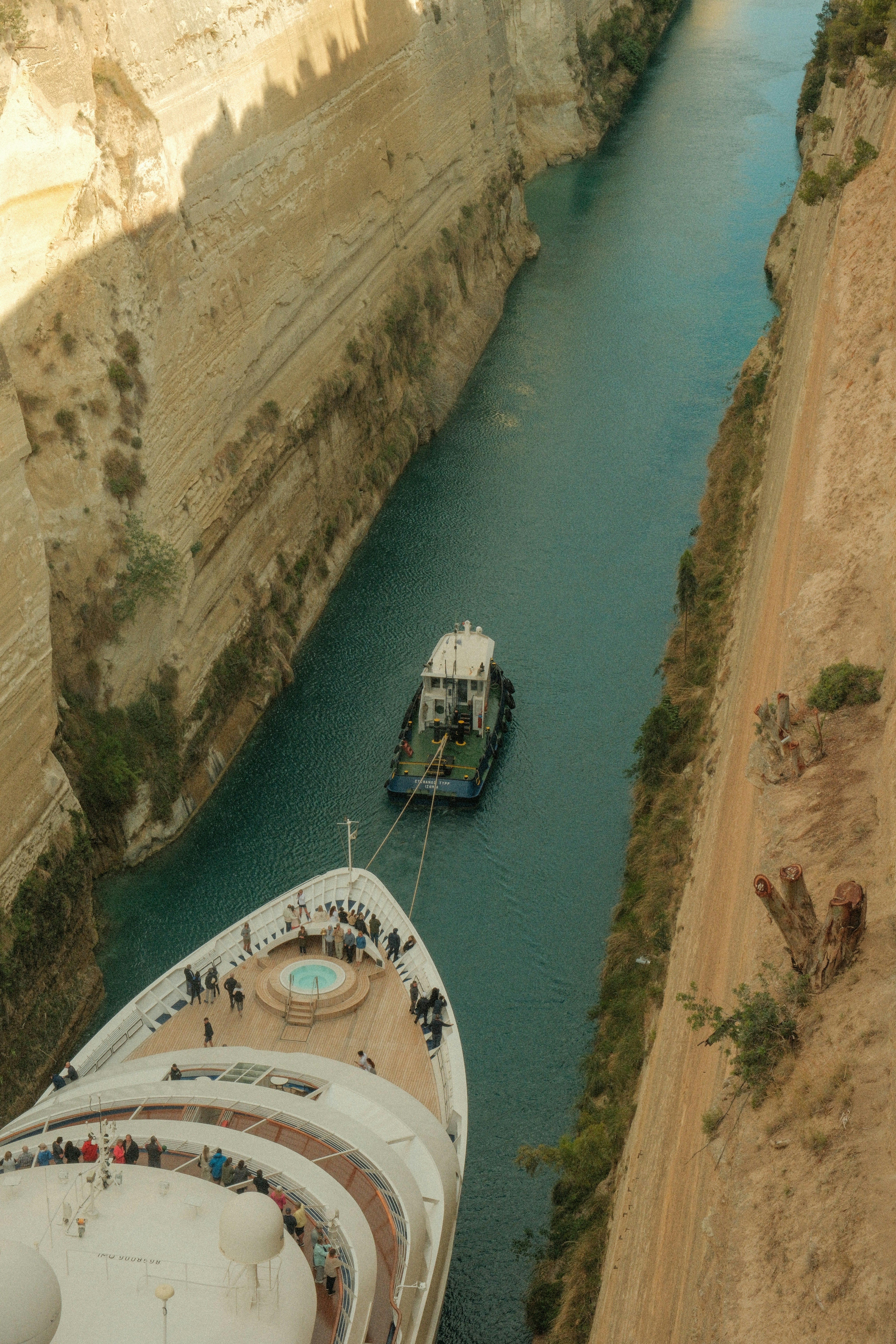 A large boat floating on top of a river next to a cliff photo – Free ...